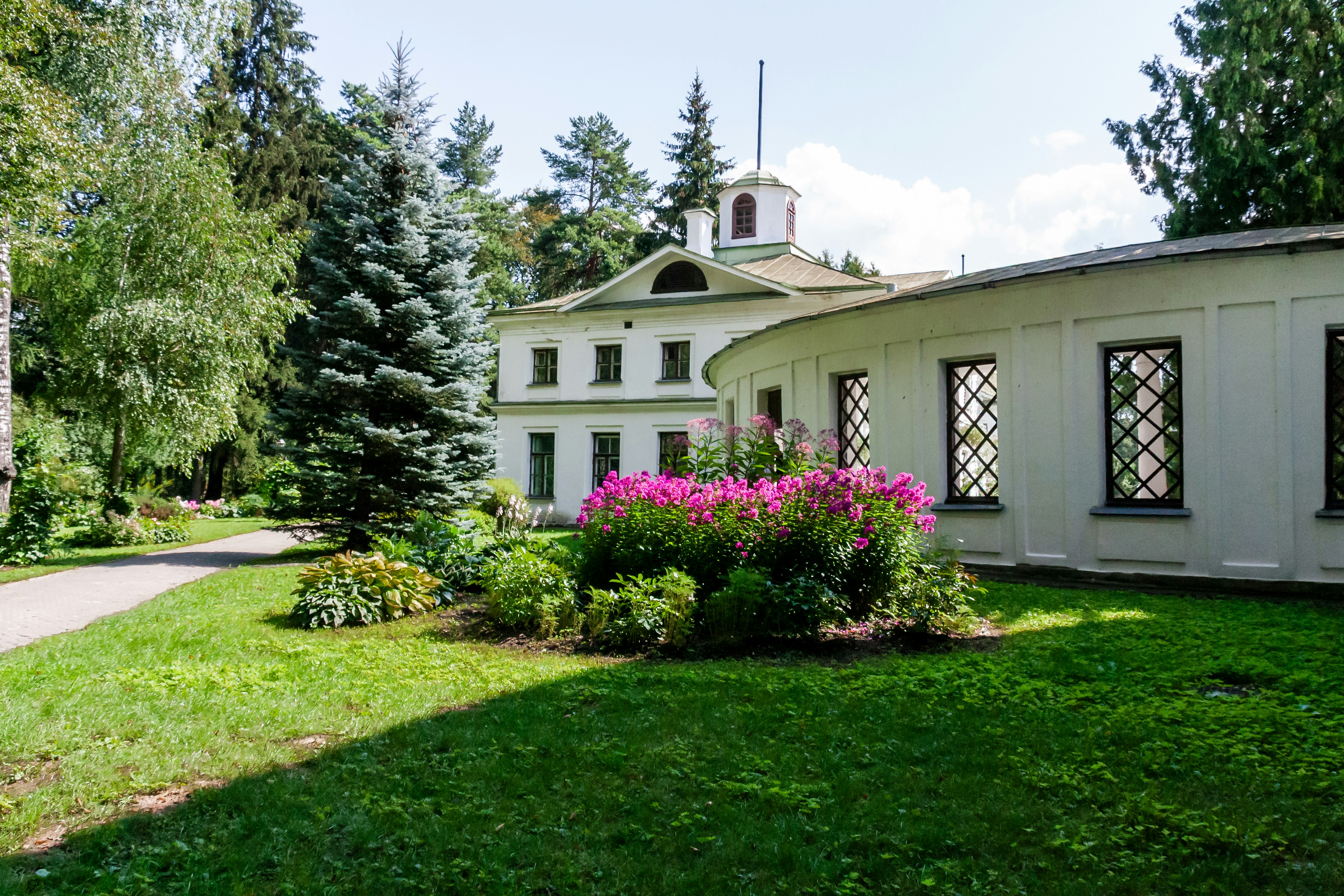 White building with a round section and garden