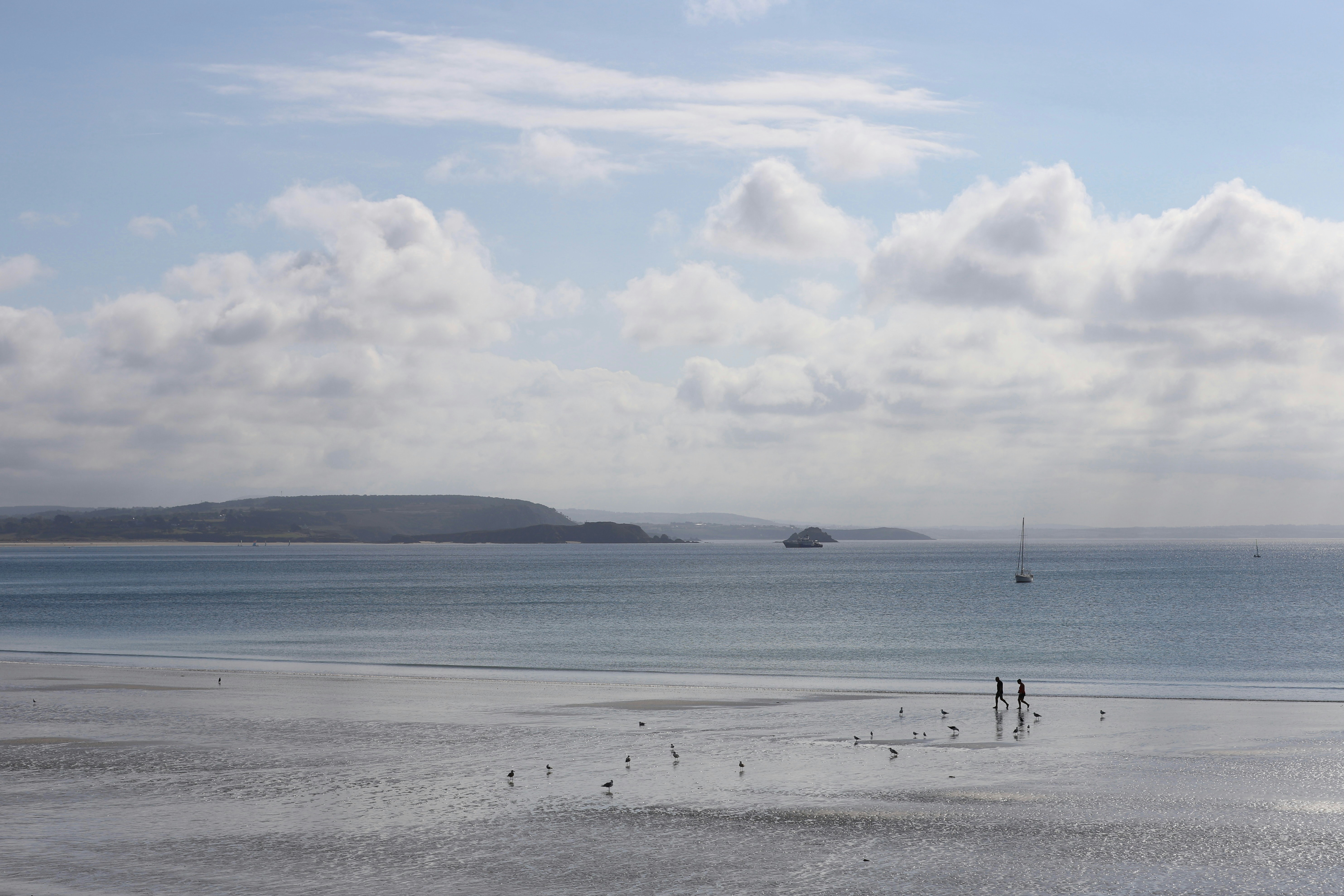 Beach, Brittany | Calm ocean with distant island and scattered clouds