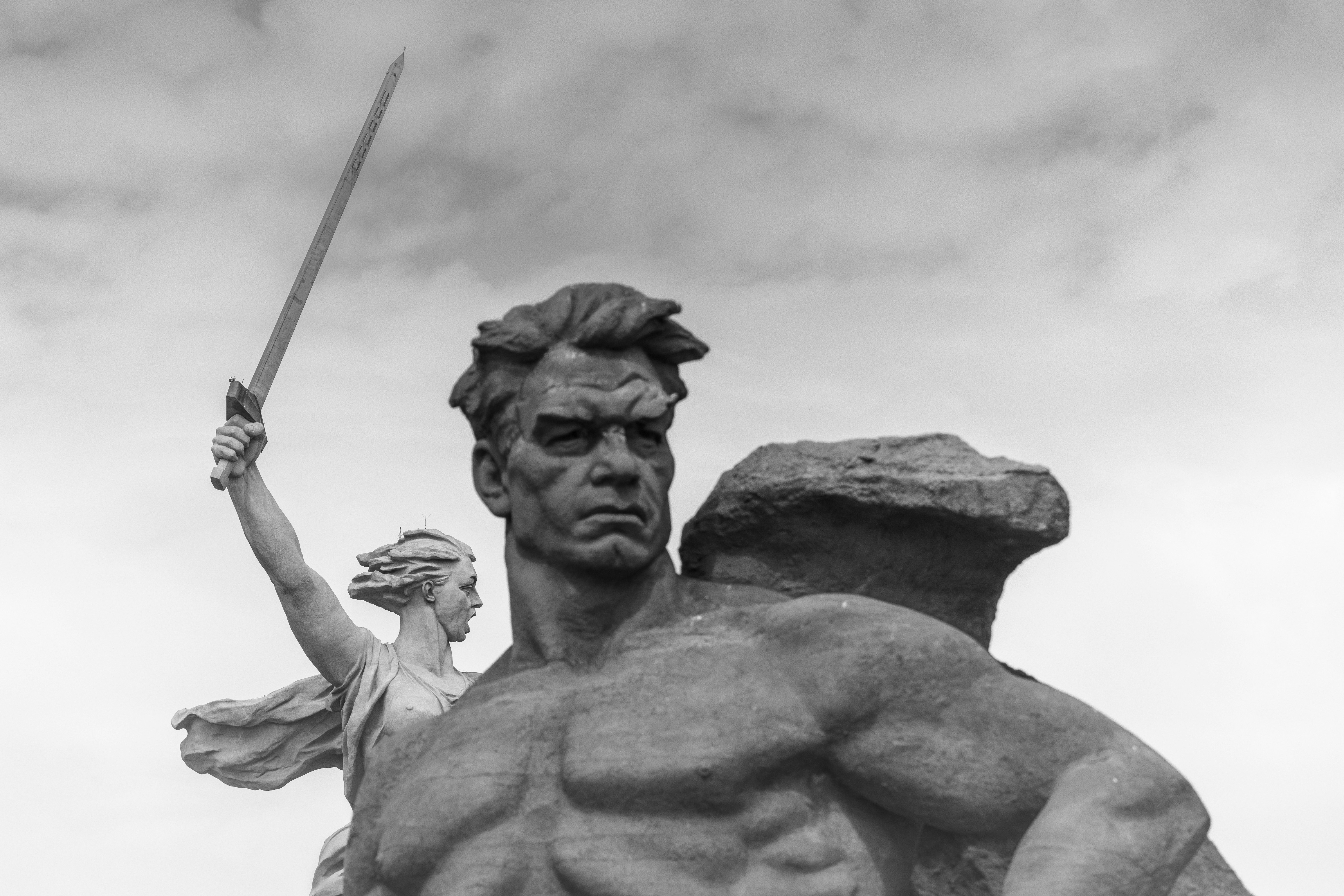 Monumental statue of a muscular man holding a sword.