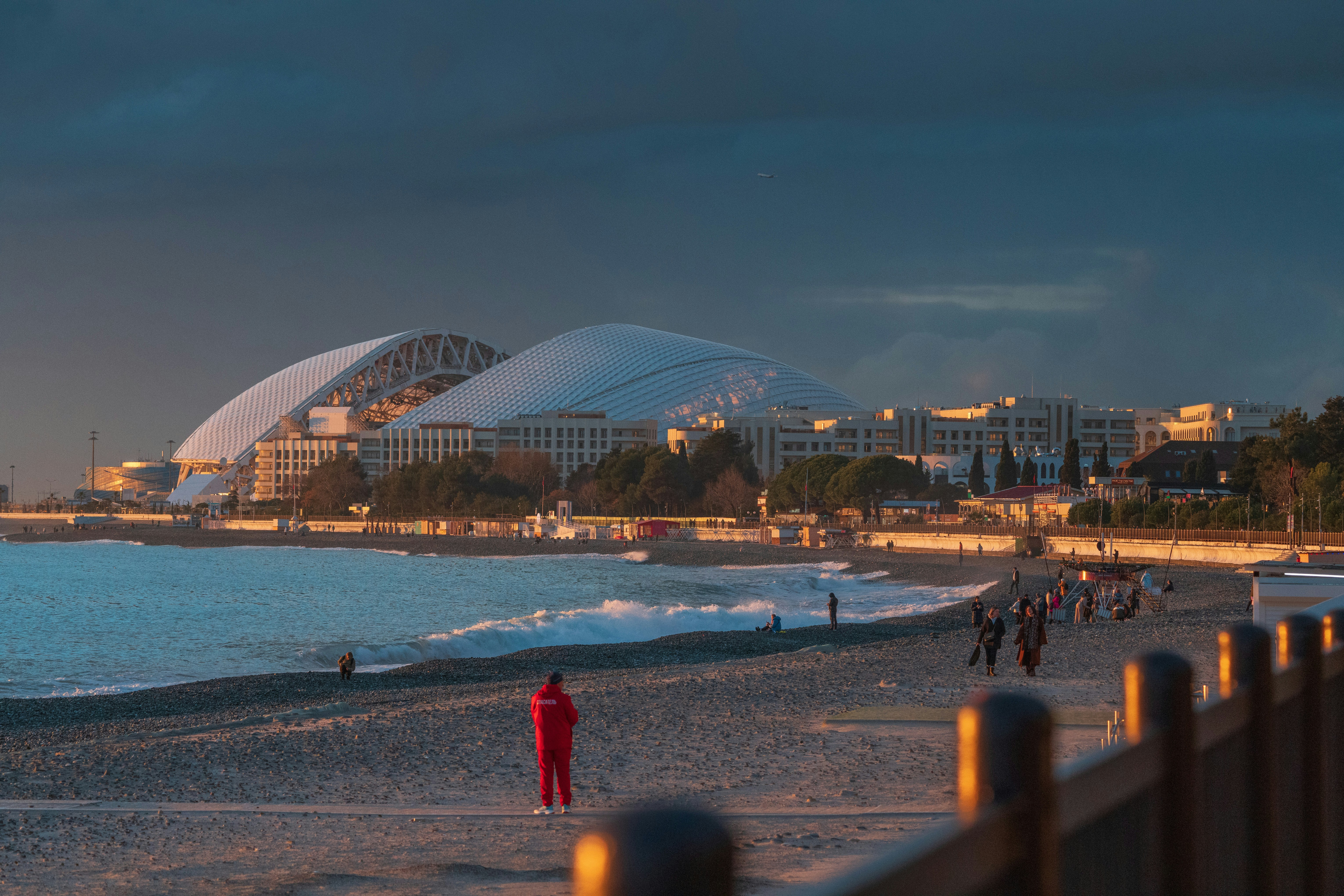 Crimson Figure at Dusk Along the Domefront Beach
