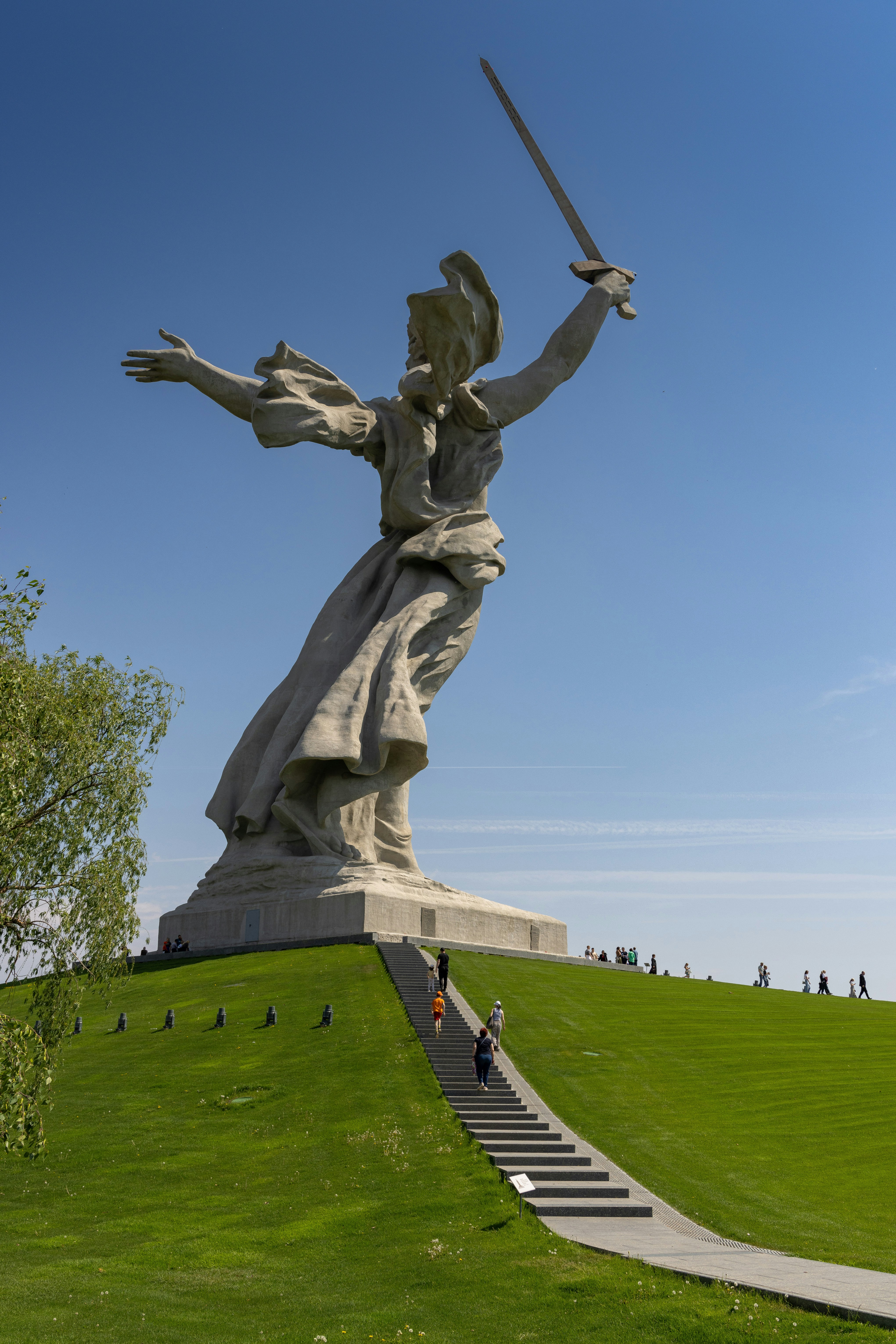 Monumental statue of a woman with a sword on a hill.