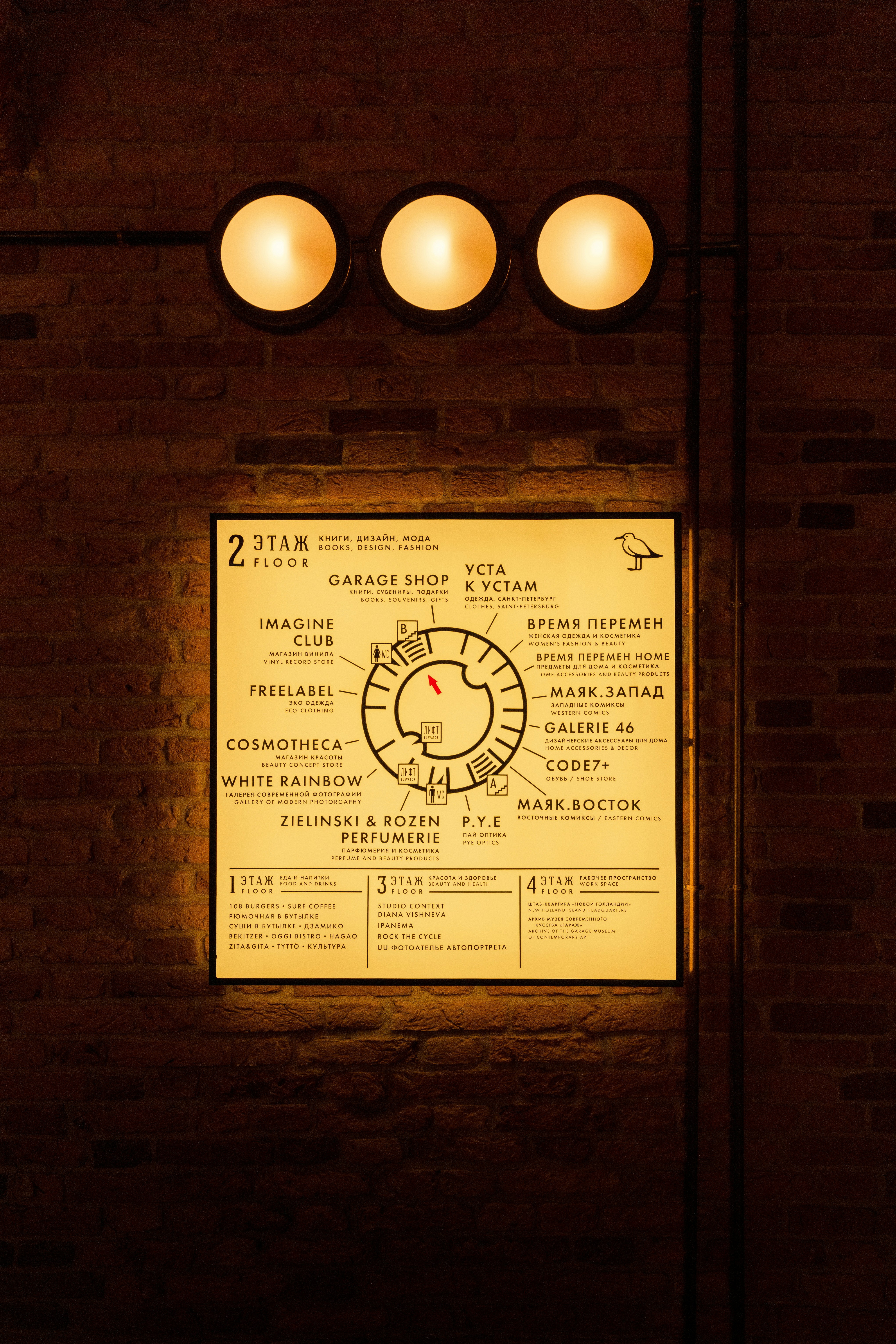 Illuminated sign on a brick wall with three lights