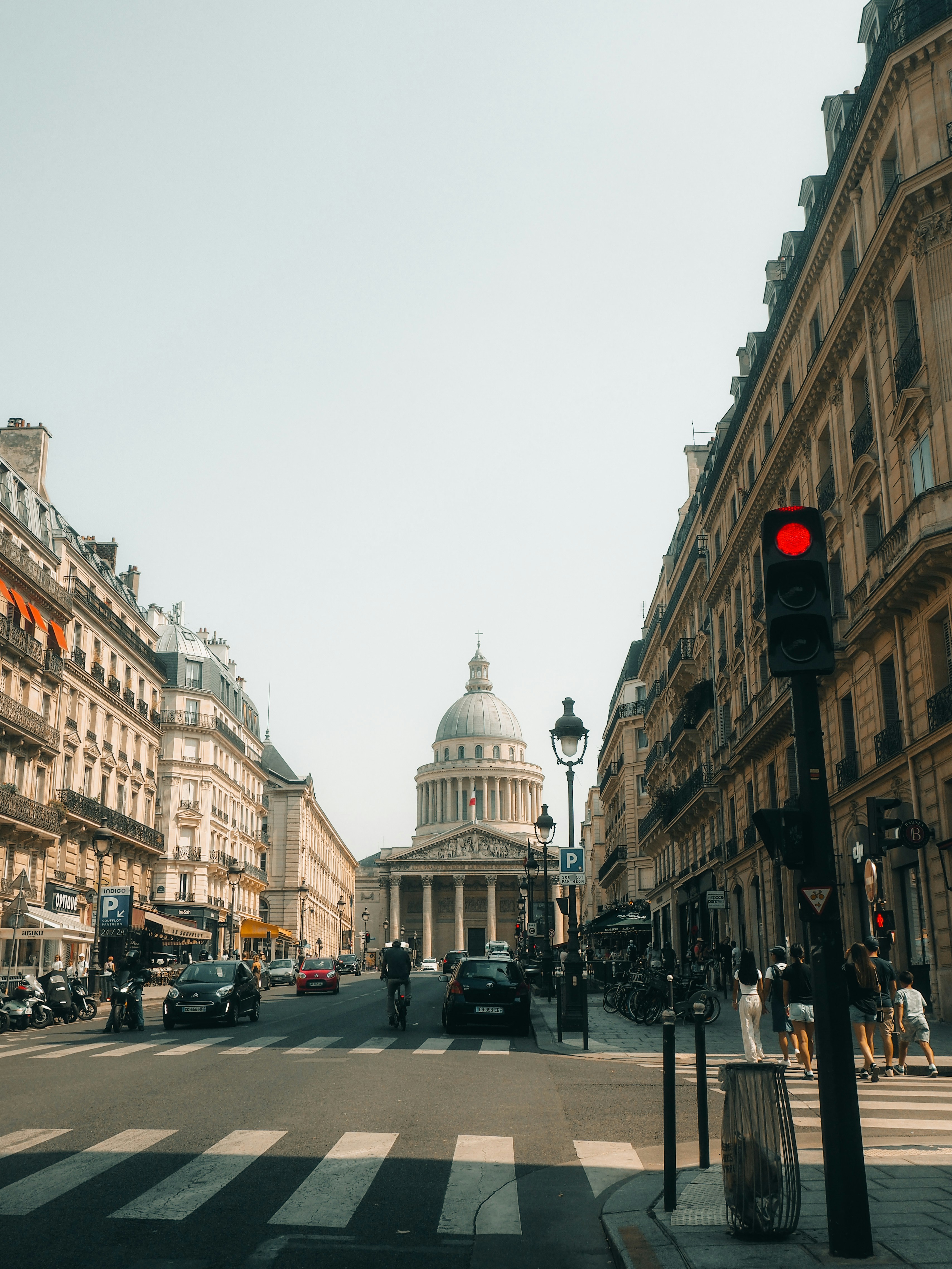 Few places embody the phrase “Paris, city of light” like this photo of the Pantheon. Captured in the late afternoon glow, the dome rises as a symbol of history, culture, and grandeur. The clear sky, the stone walls, and the narrow Parisian street combine to create a scene that feels at once historic and modern. It’s an image of travel inspiration, reminding you of walking tours, hidden corners, and architectural wonders around every bend. But beyond the monumental, this shot whispers with small details: the streetlamp curving overhead, the signboard of a nearby café, the people gathering.Lens by Benji