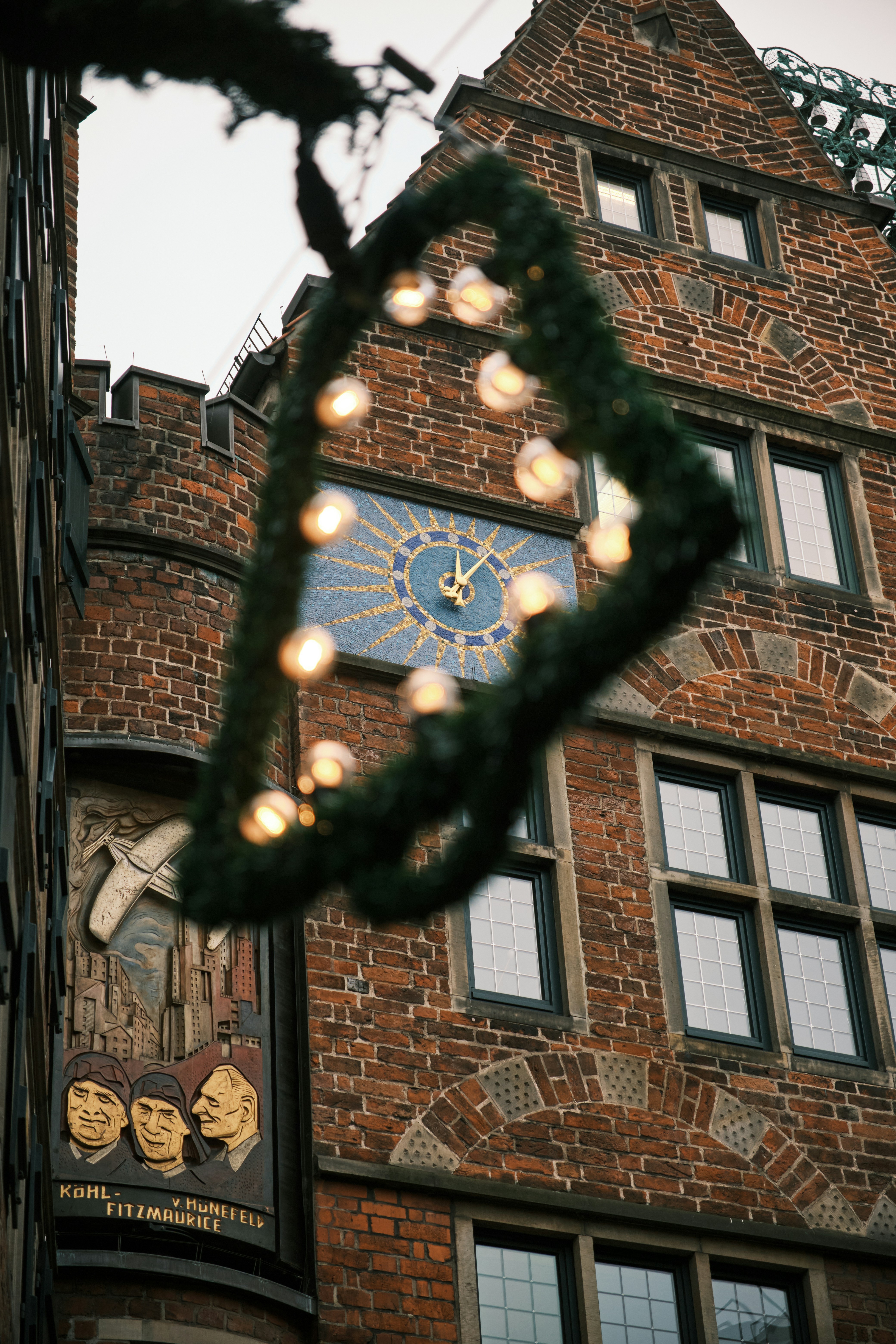 Brick building with clock and festive lights