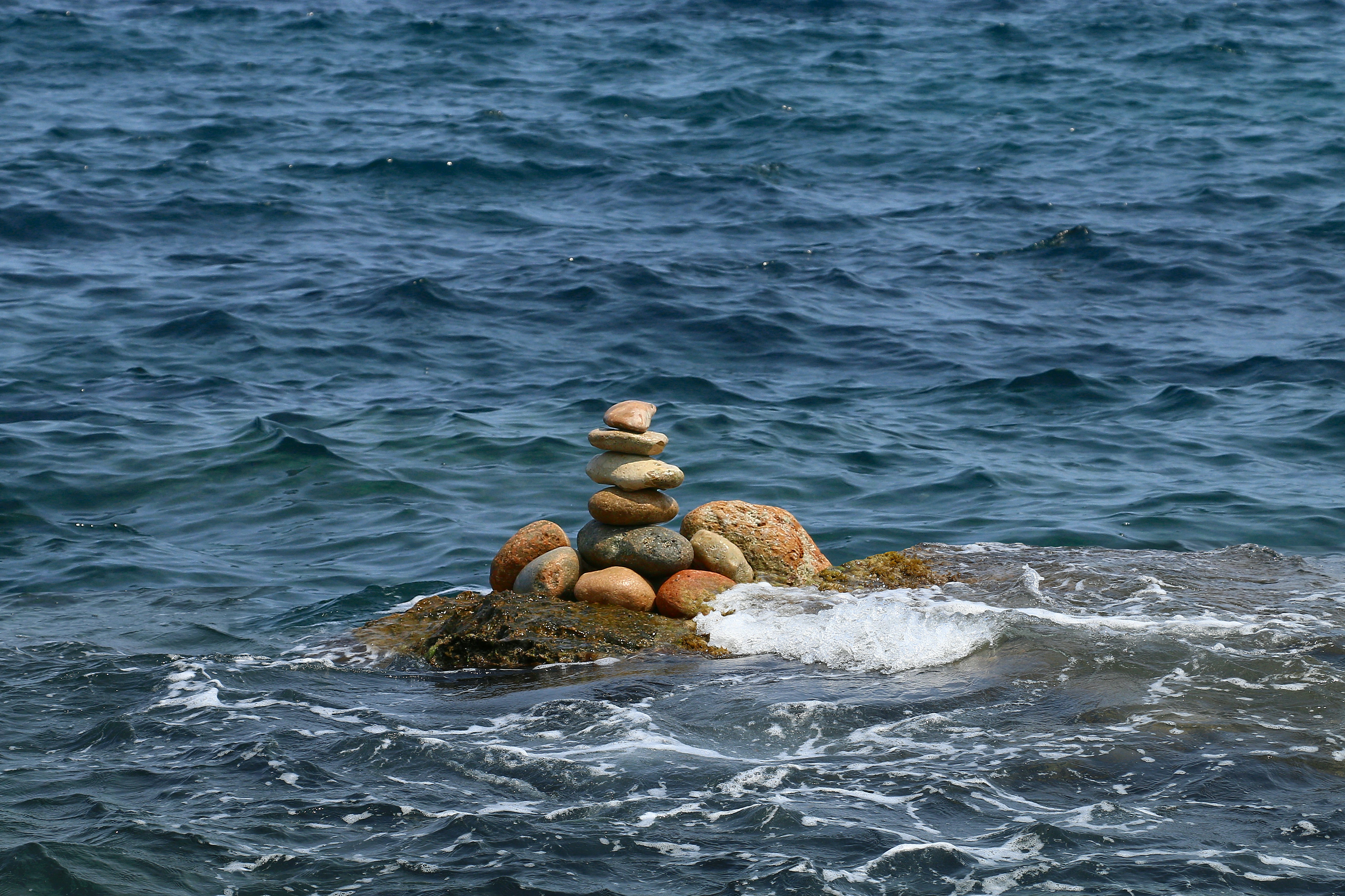 This natural stone cairn is supposed to create a sense of harmony, balance and calm ...personally the rising sea levels kinda put me on edge! | Stacked stones on a rock in the ocean