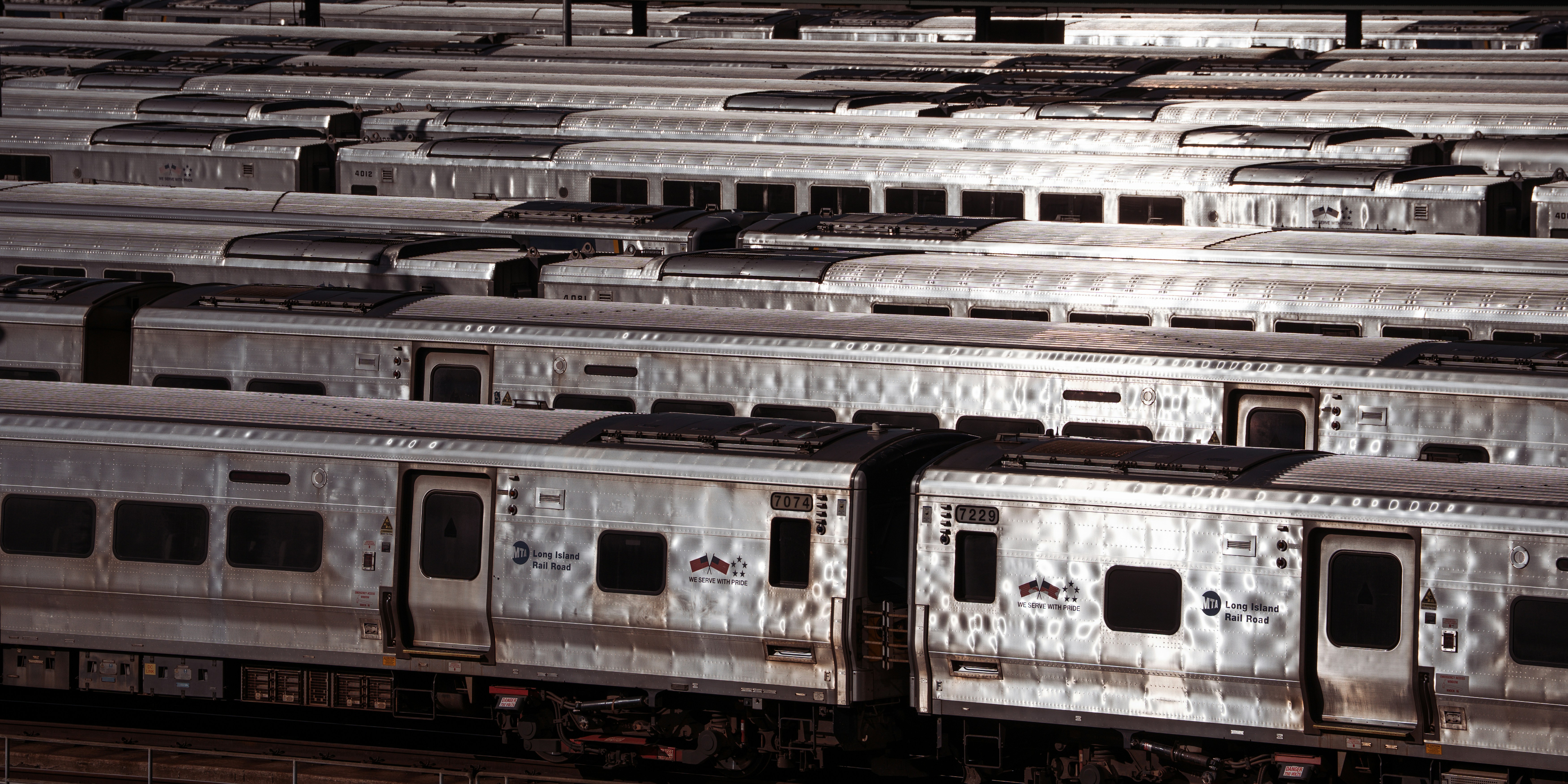 Rows of silver passenger trains parked on tracks.
