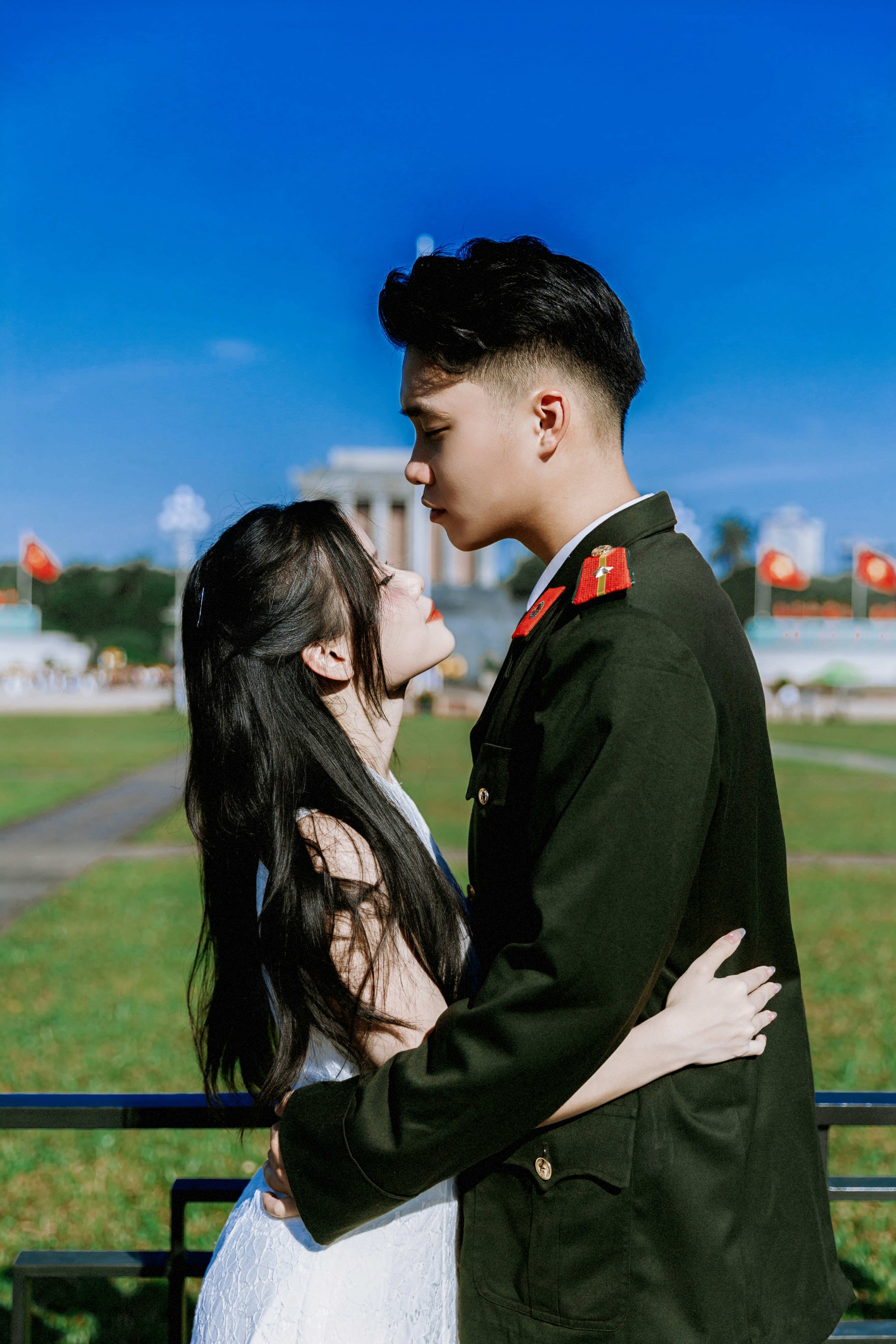 Couple portrait outdoors in Hanoi | Young couple embracing outdoors with building in background