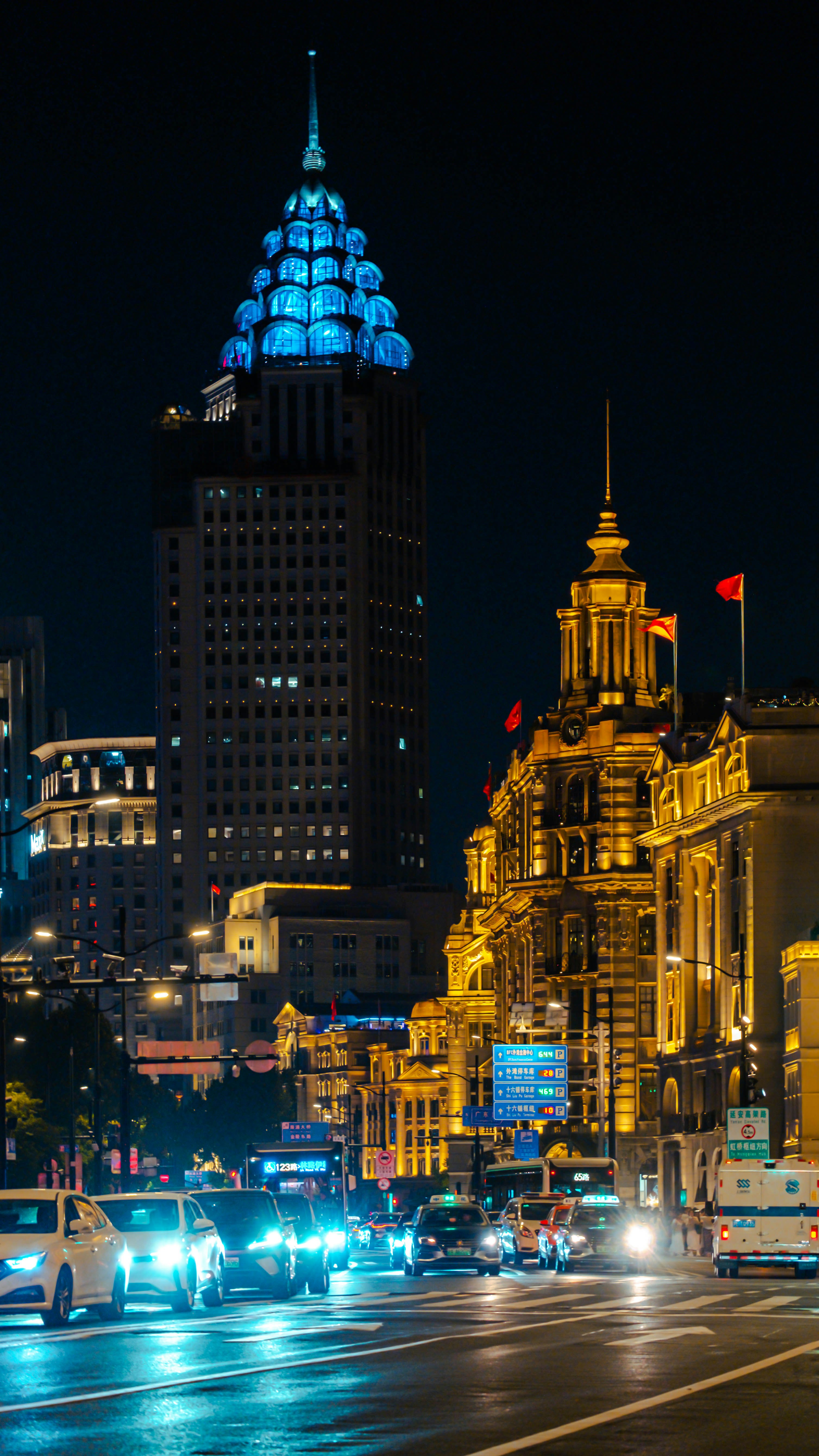 Cityscape at night with illuminated buildings and traffic.