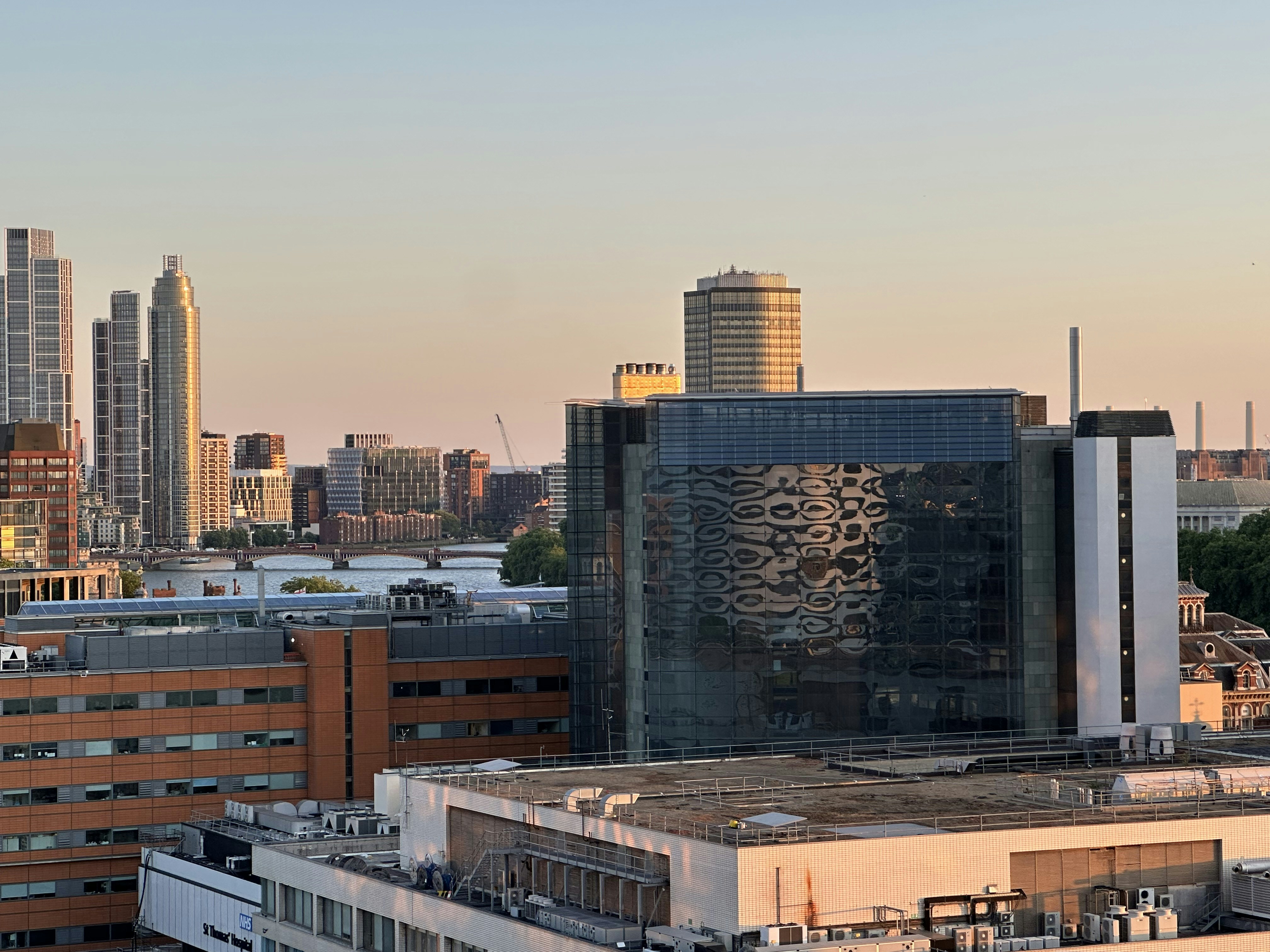 City skyline featuring a blend of contemporary architecture and reflections on glass surfaces during golden hour.