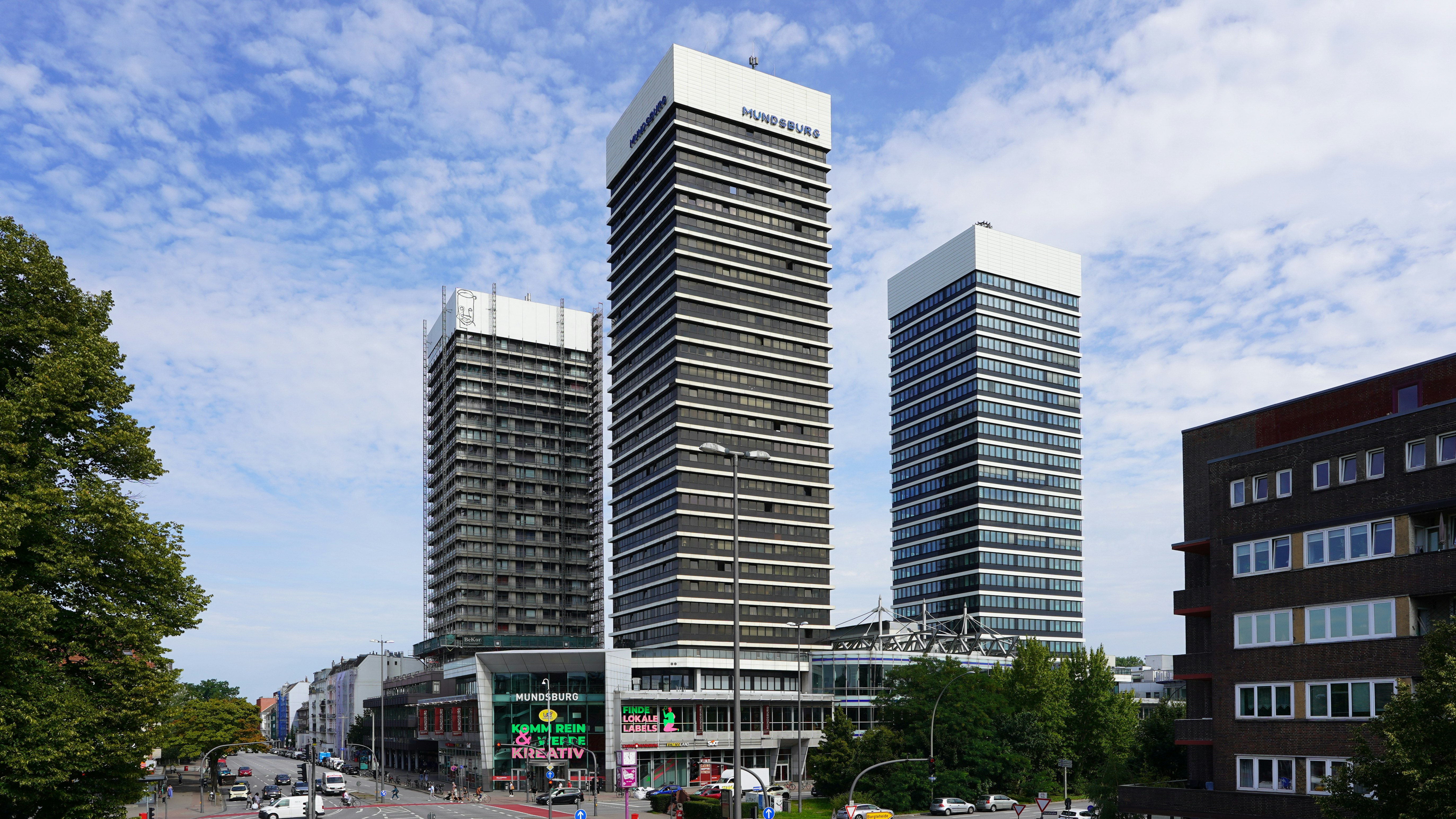 Three tall modern skyscrapers against a blue sky.