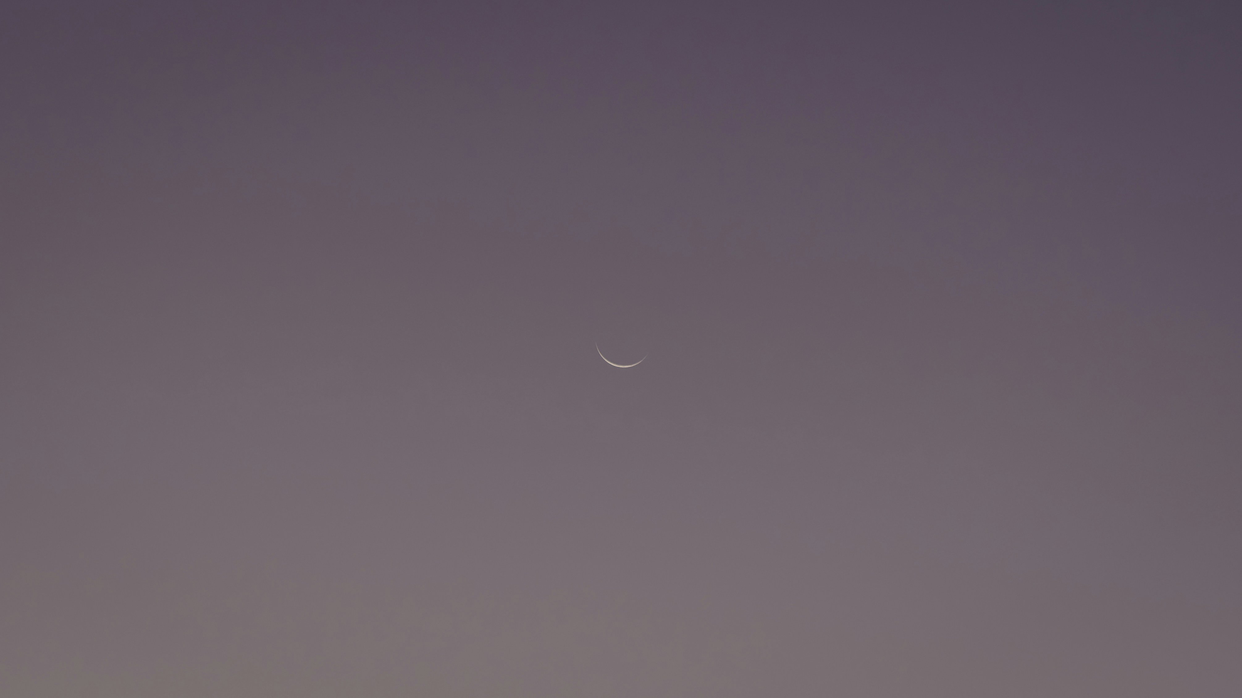 Small airplane flying in a dusky sky
