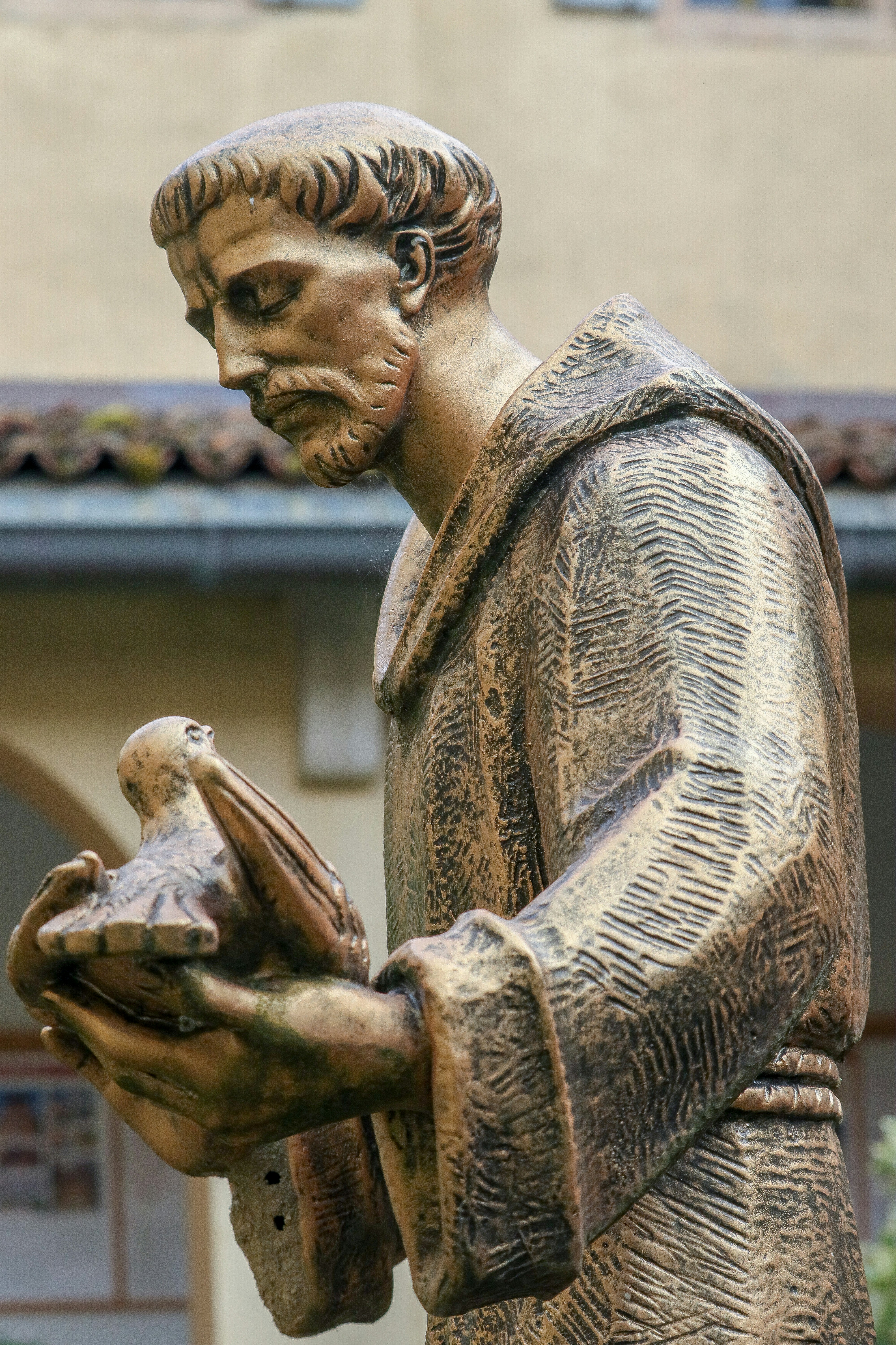 Bronze statue of a monk holding a bird