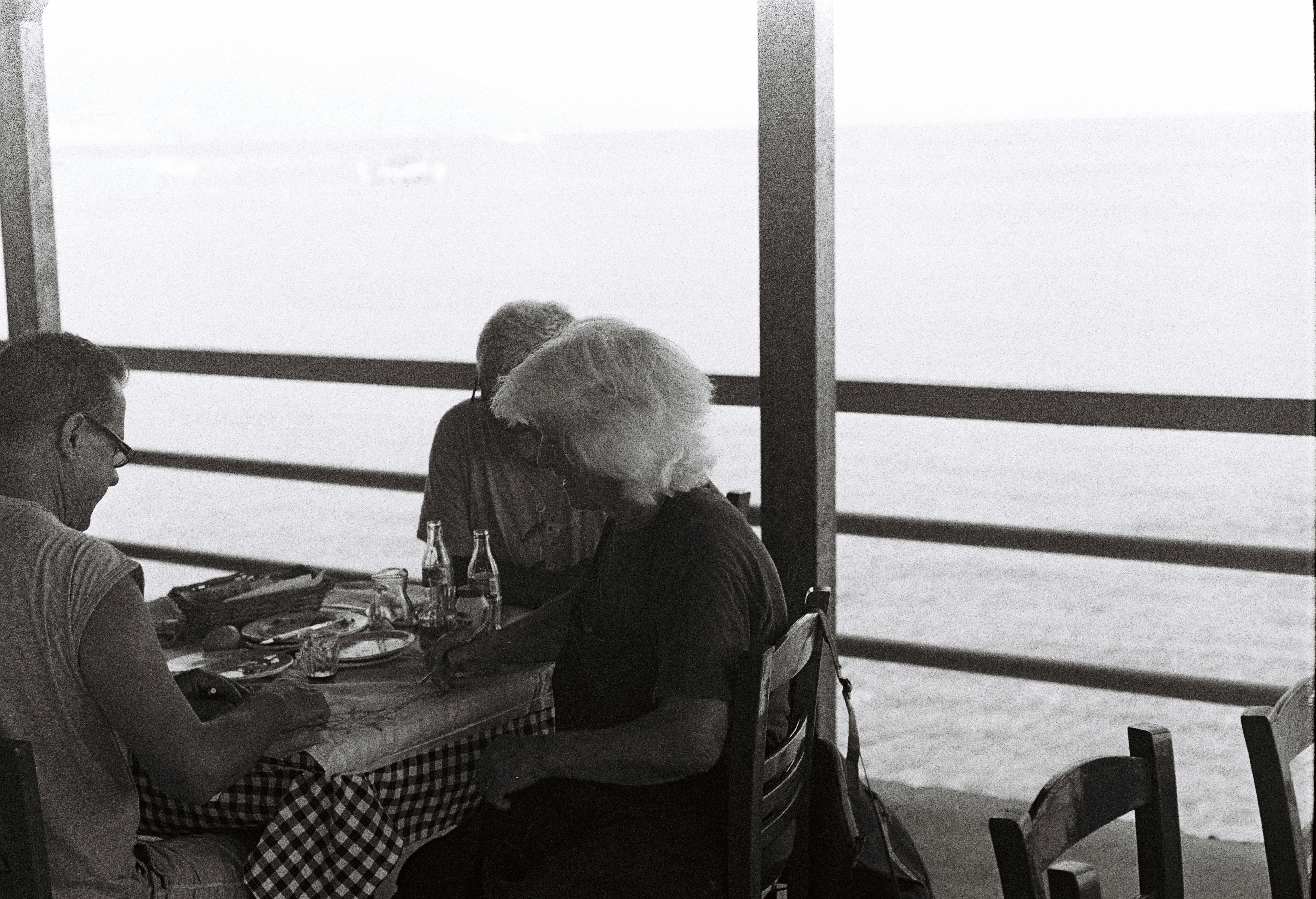 Fish tavern owners on Greek island, Evia | People dining at a table overlooking the ocean