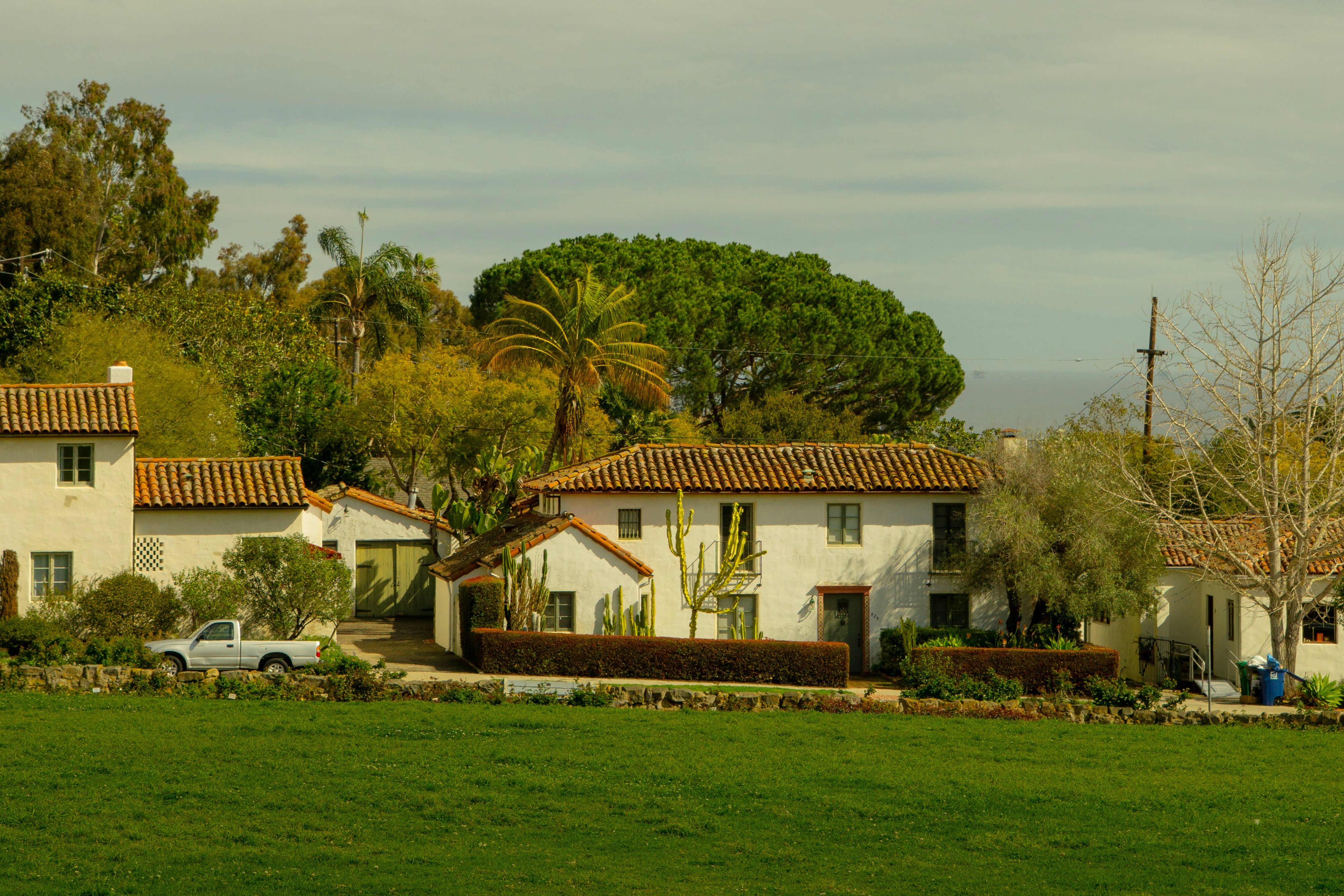 White houses with tile roofs nestled among trees.