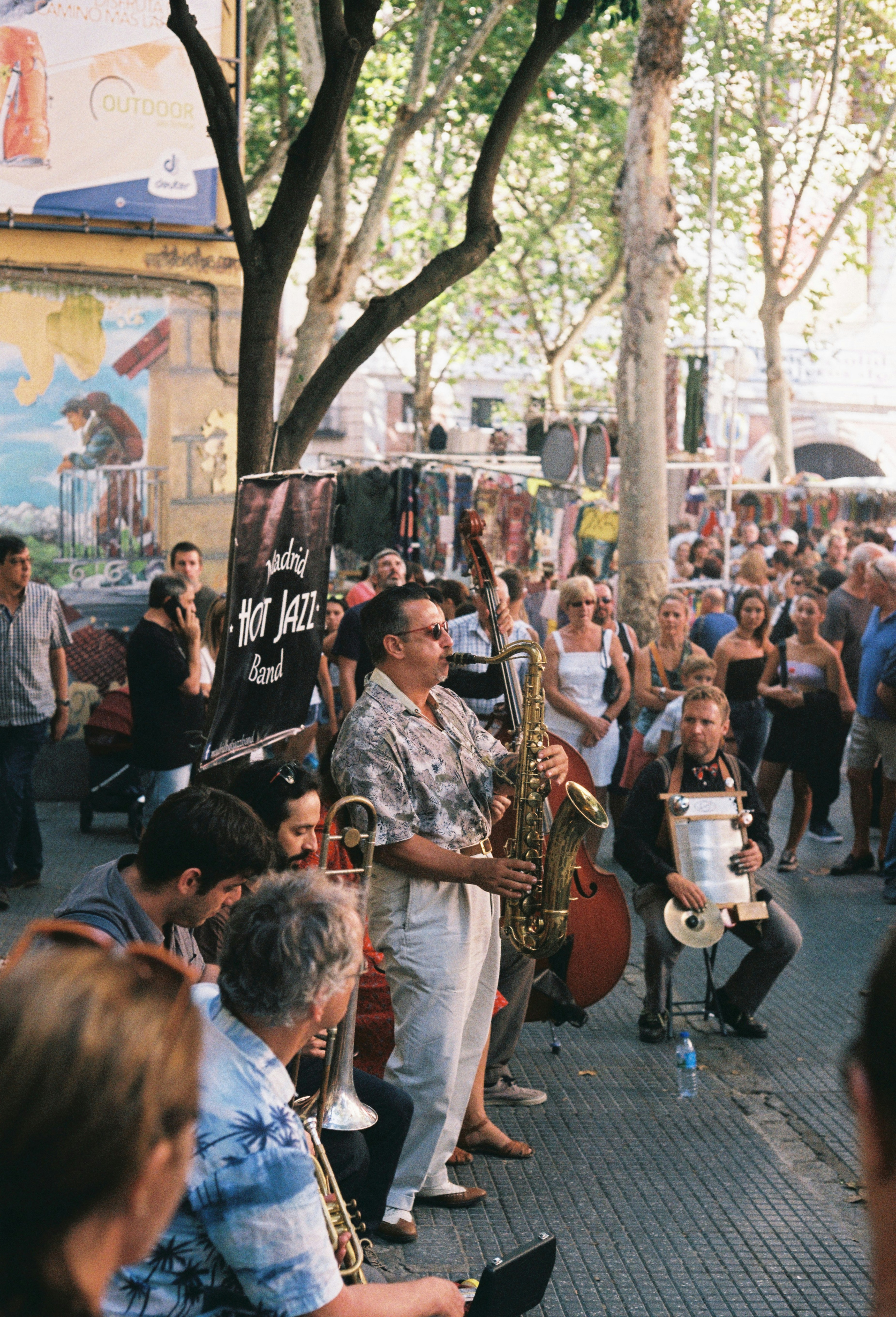 a jazz band performing on the street in Madrid | A jazz band performs for a crowd outdoors.