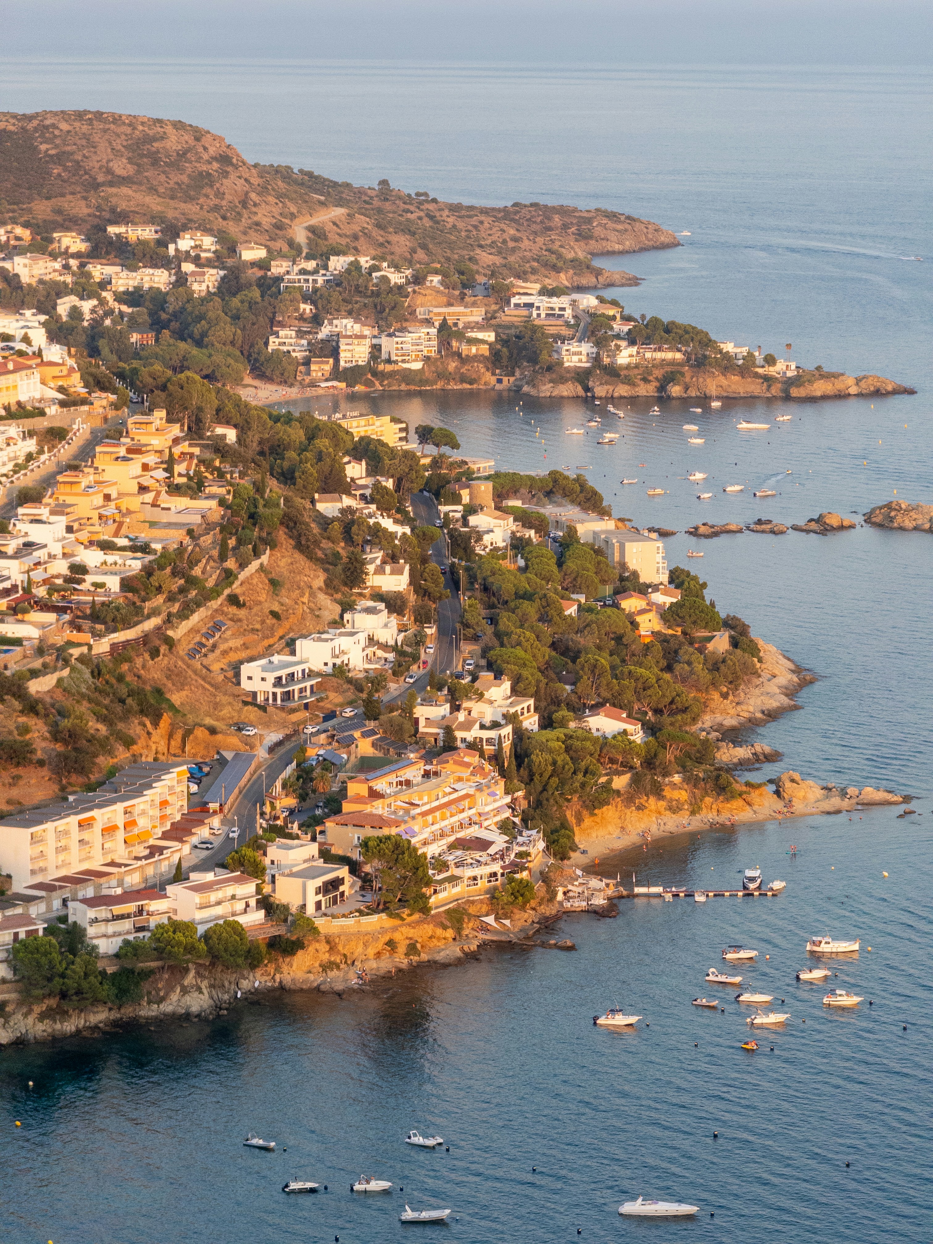 Sunlit Peninsula: A Winding Coastal Village Clinging to the Rocky Edge