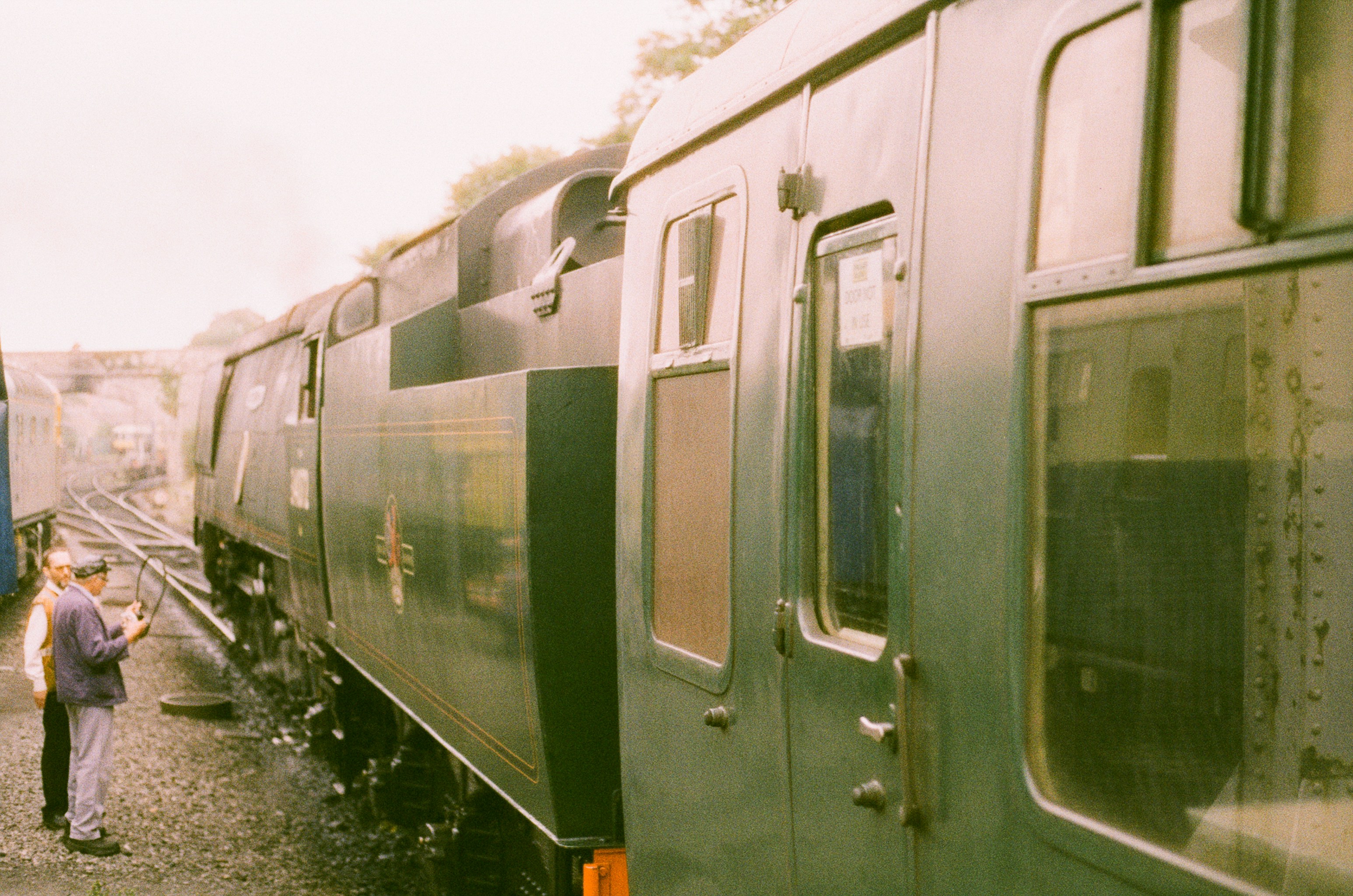 Two people stand beside a vintage green train photo – Free Film ...