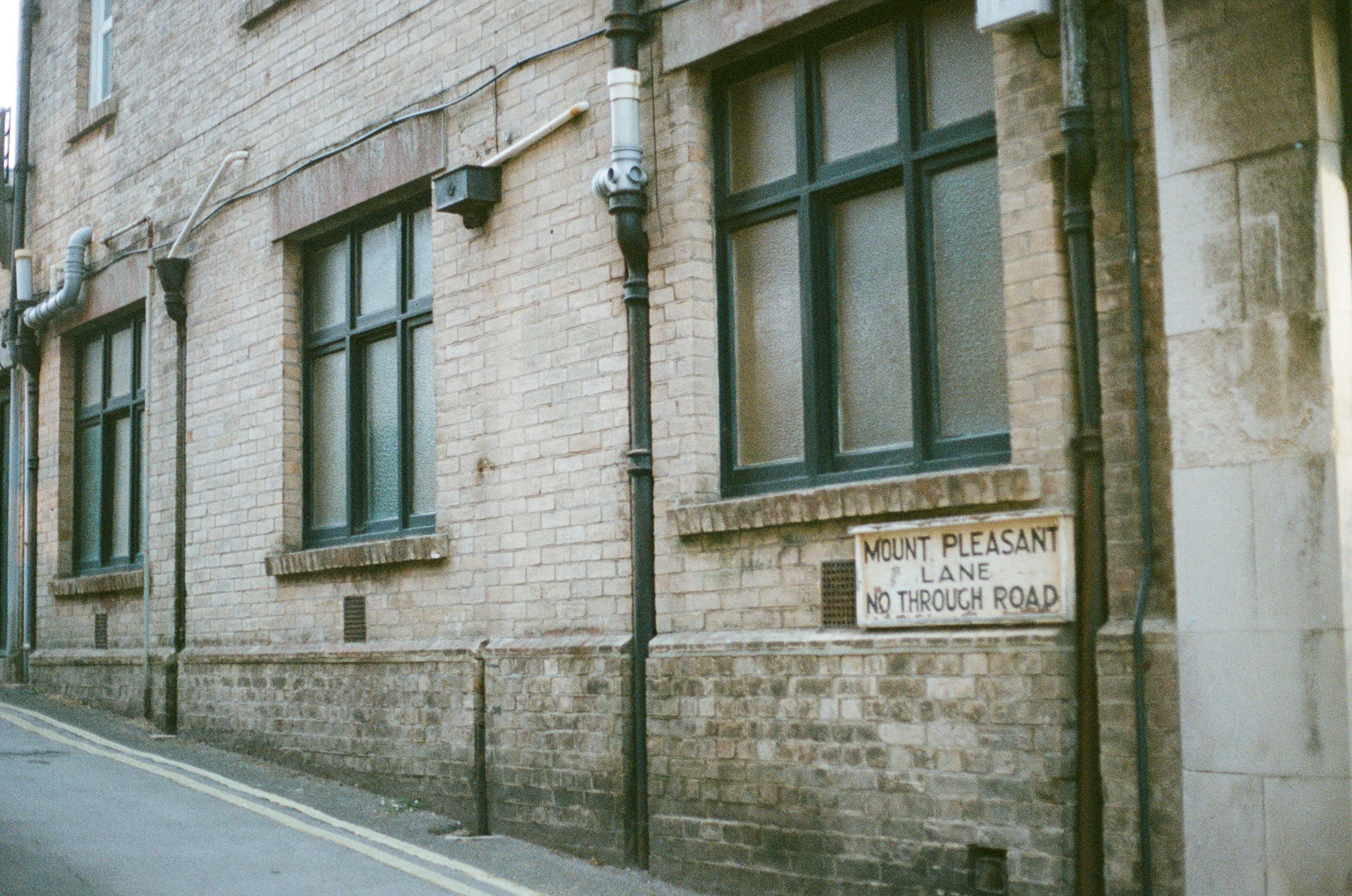 Brick building with windows and street sign. photo – Free Film ...