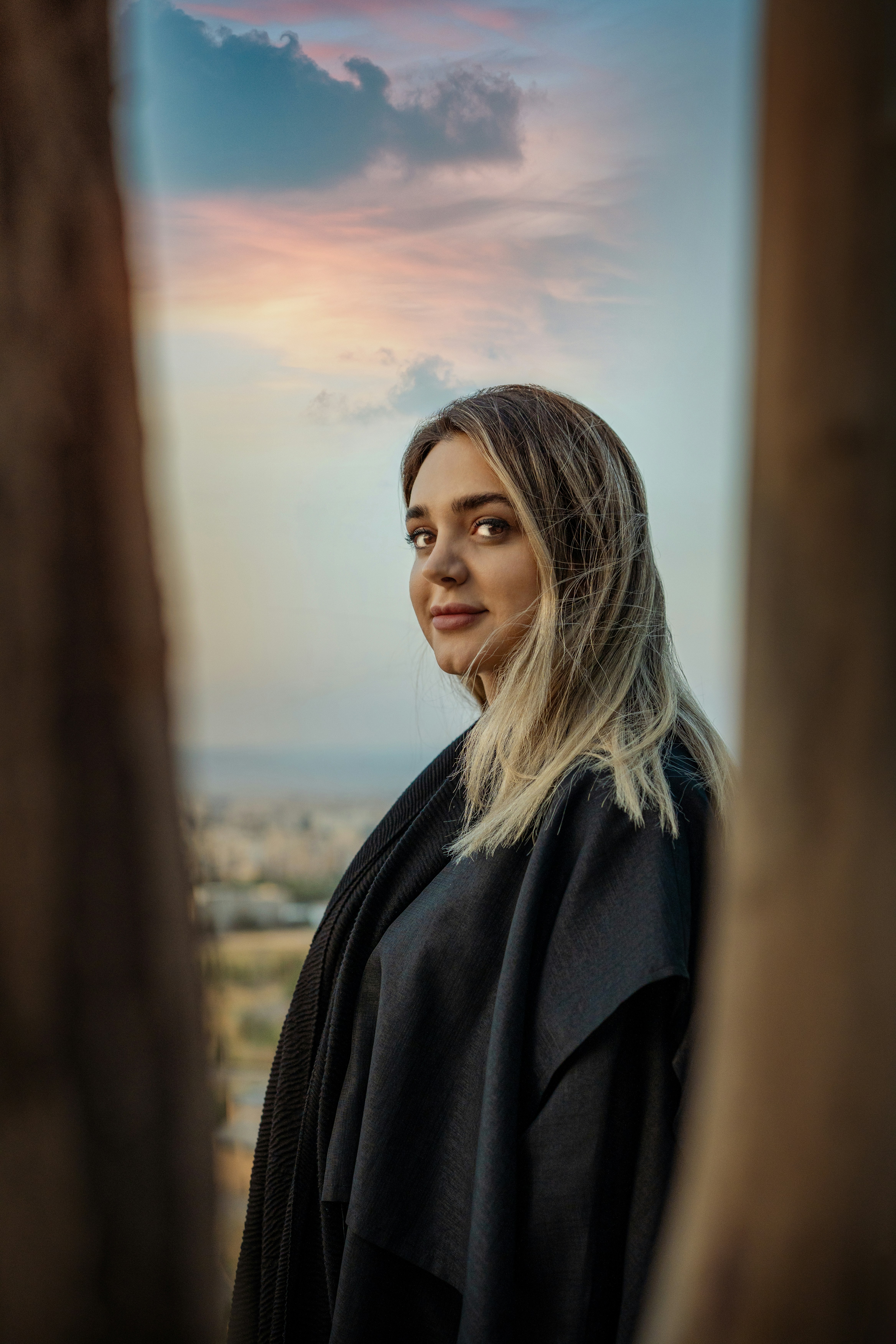 Portrait Through Weathered Timber: A Sunset Framing of Quiet Confidence