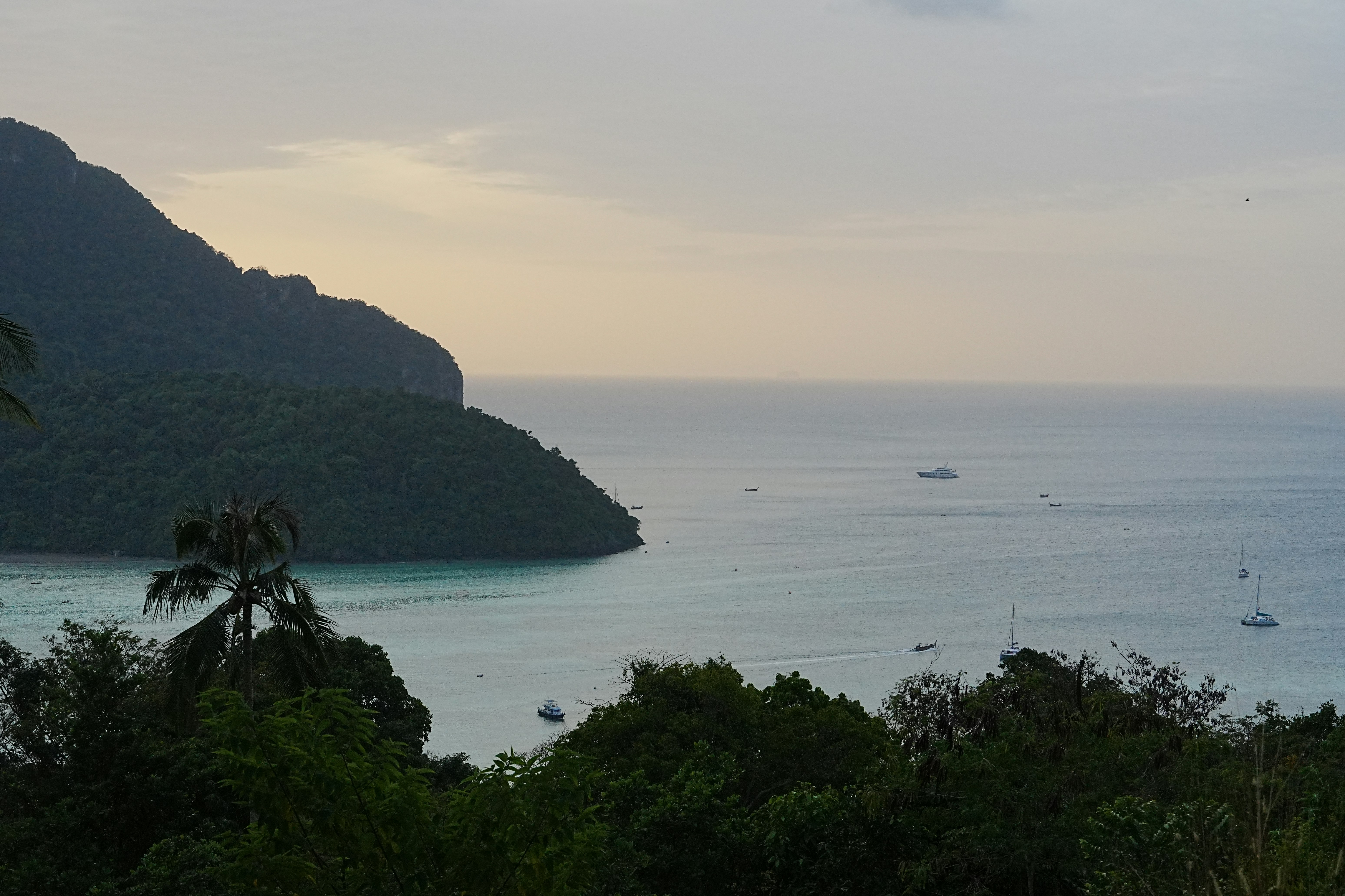 Calm ocean with a forested island at sunset