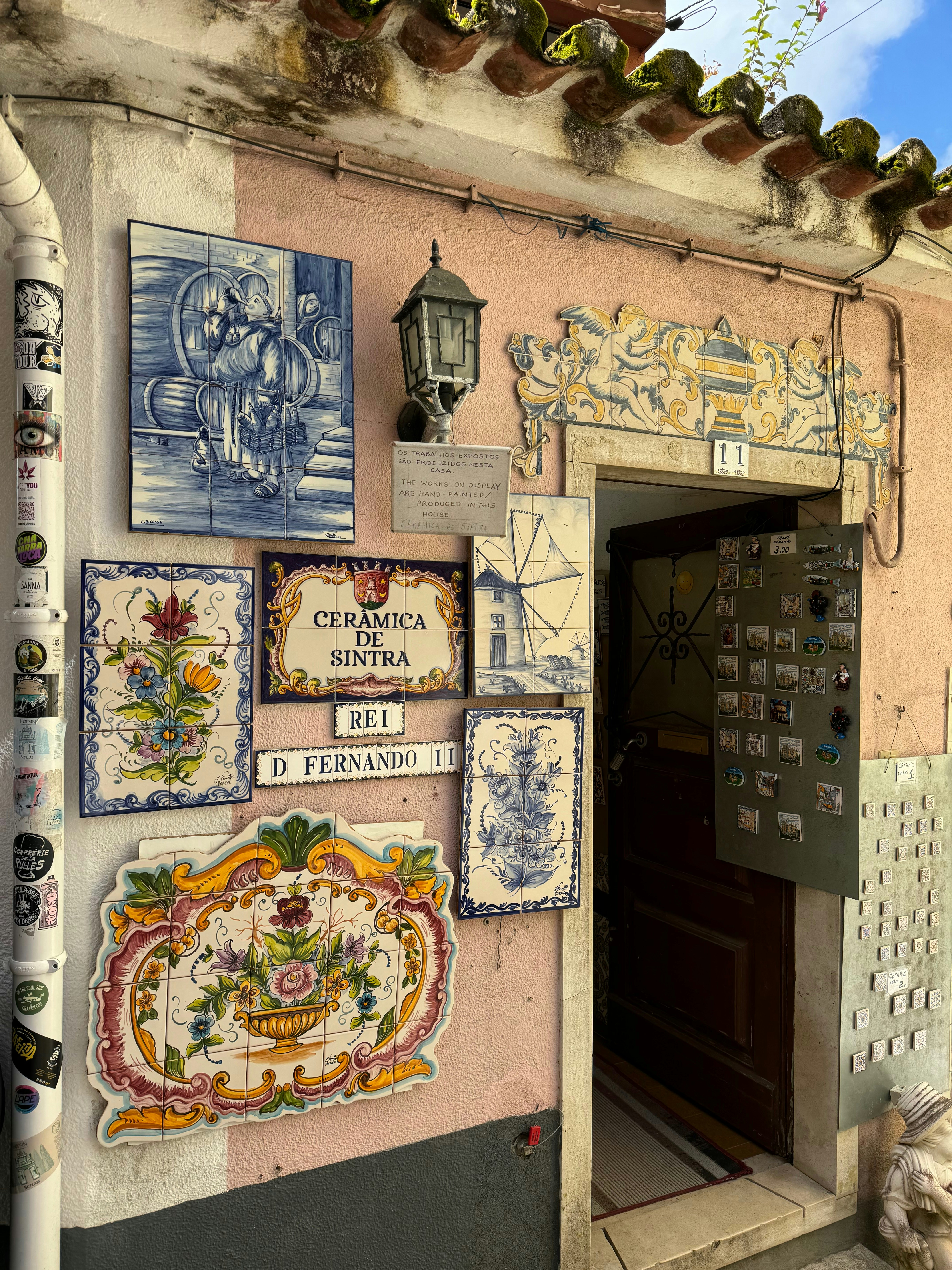Ornate blue and white tiles adorn a pink building facade.