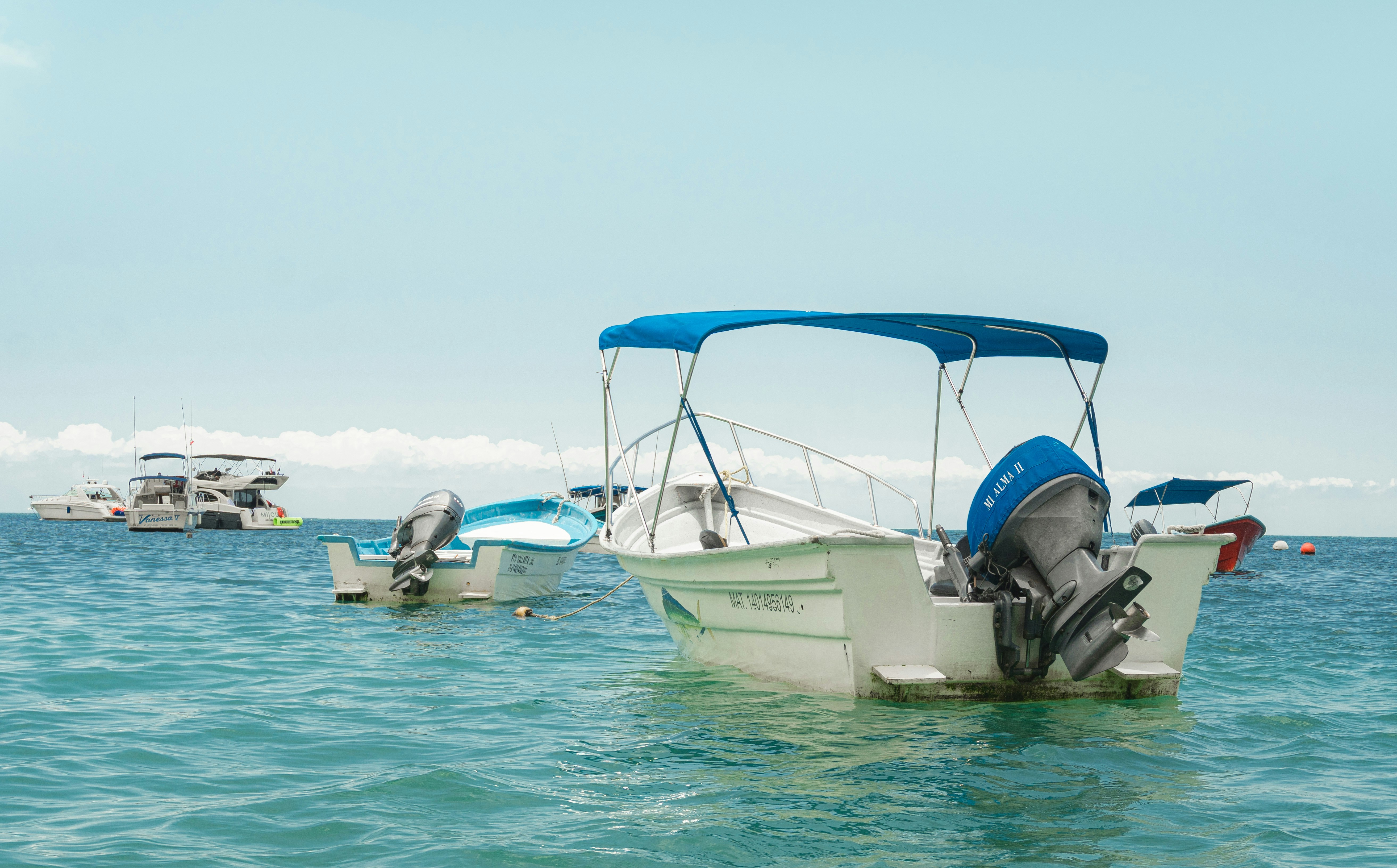 Motorboats anchored in clear turquoise ocean water.