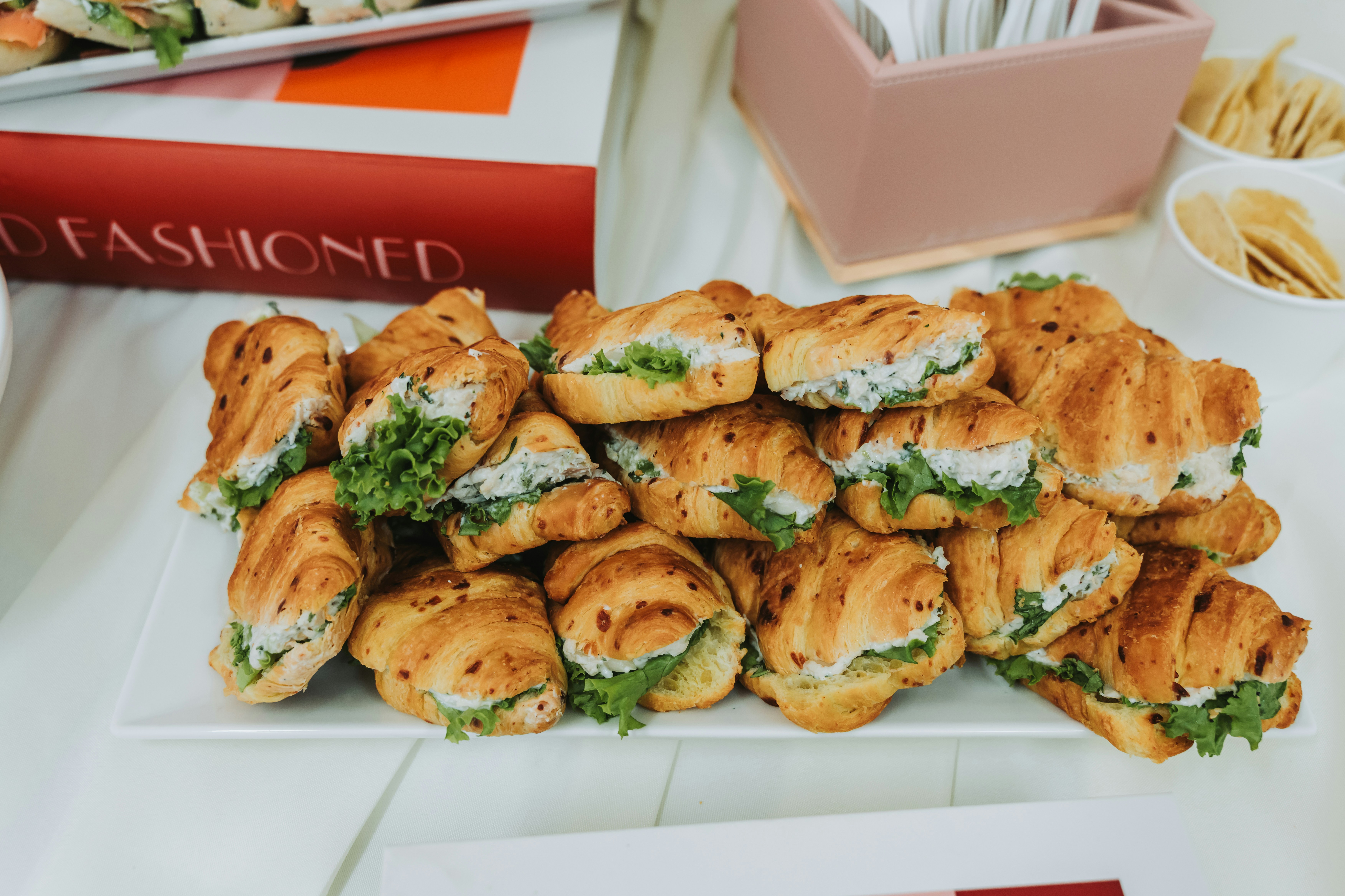 Croissant sandwiches filled with cream cheese and greens.