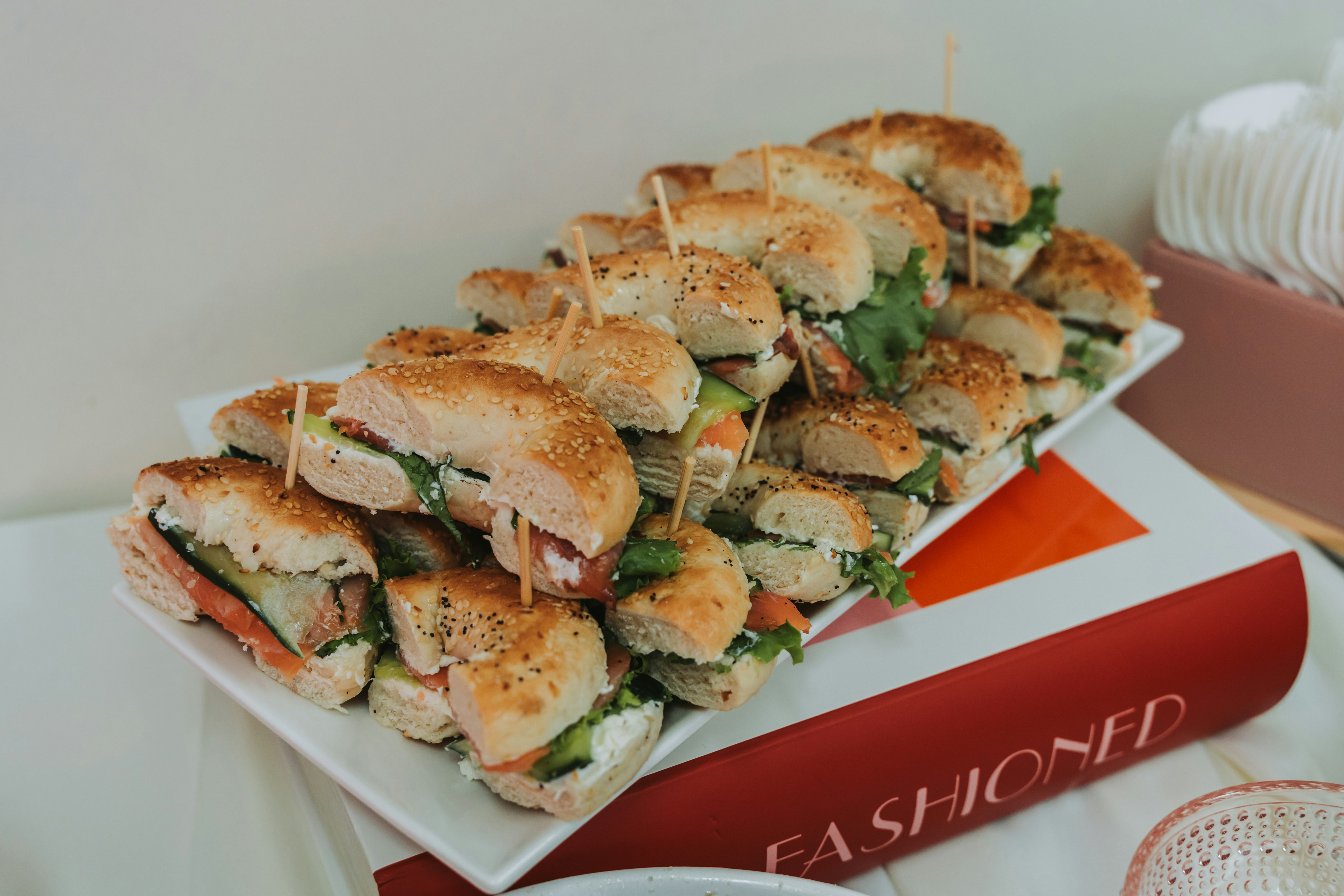 A platter of mini salmon bagels with fresh ingredients.