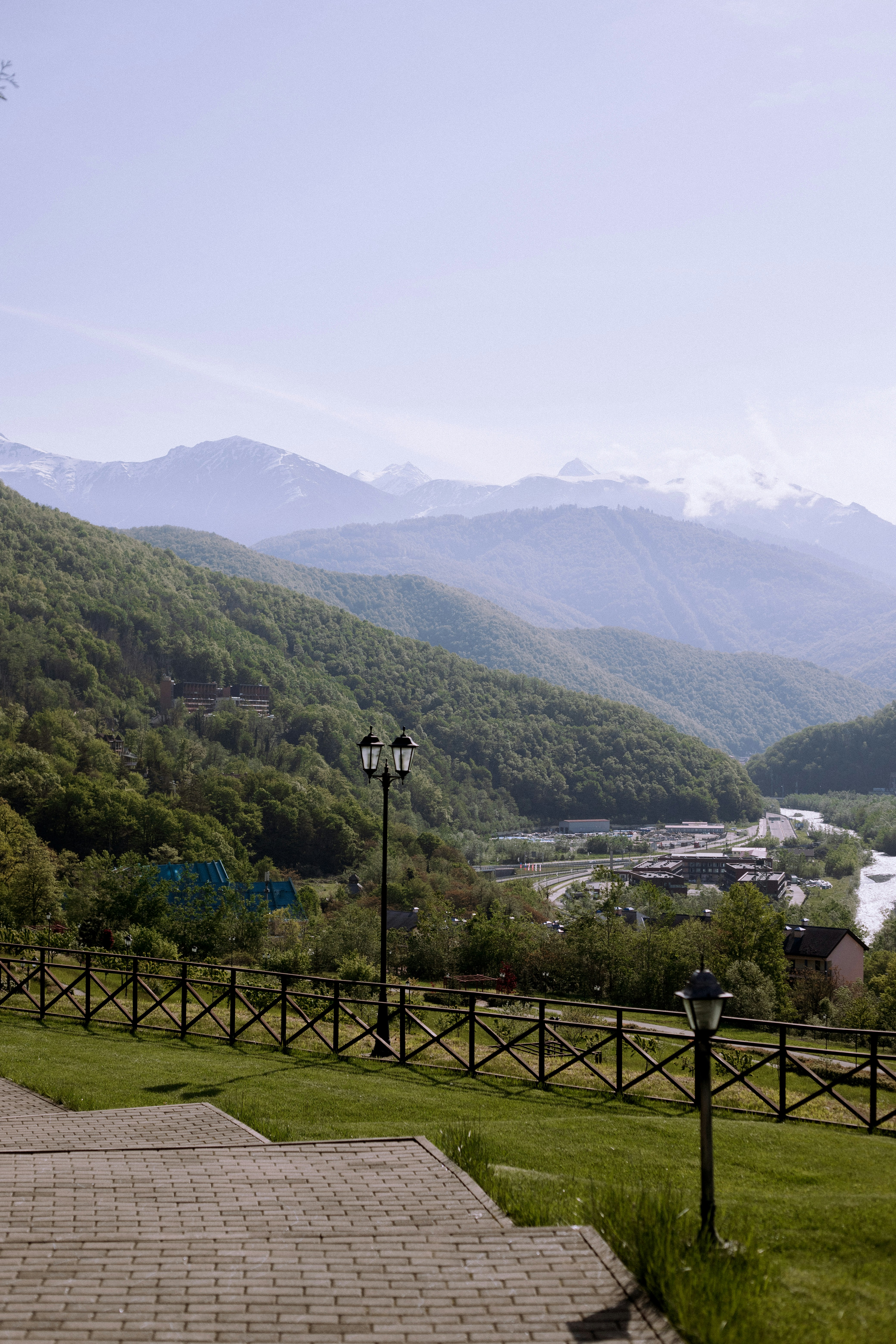 Lush green mountains with a village and river below.
