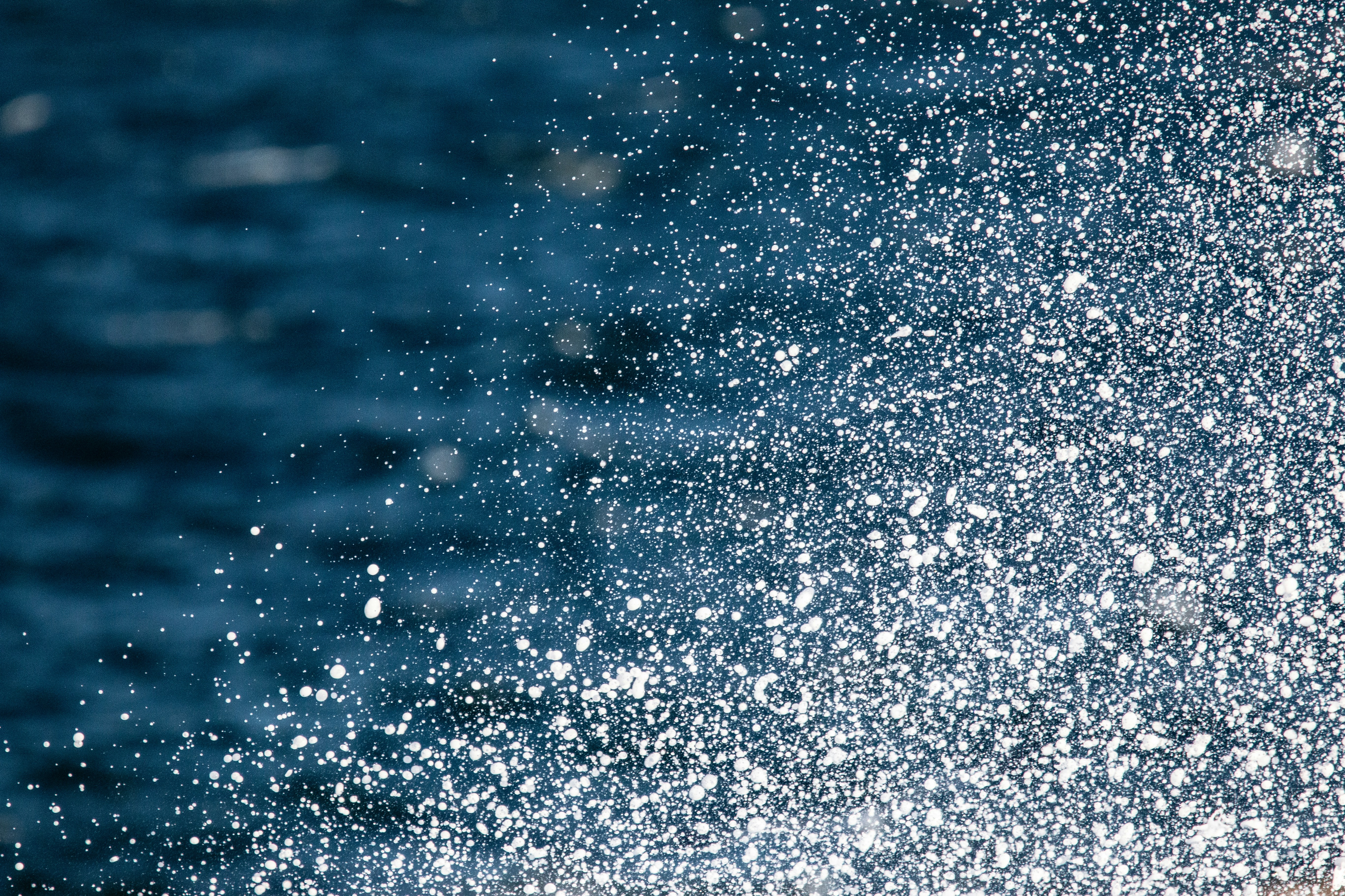Splashing water droplets with a blurred blue background