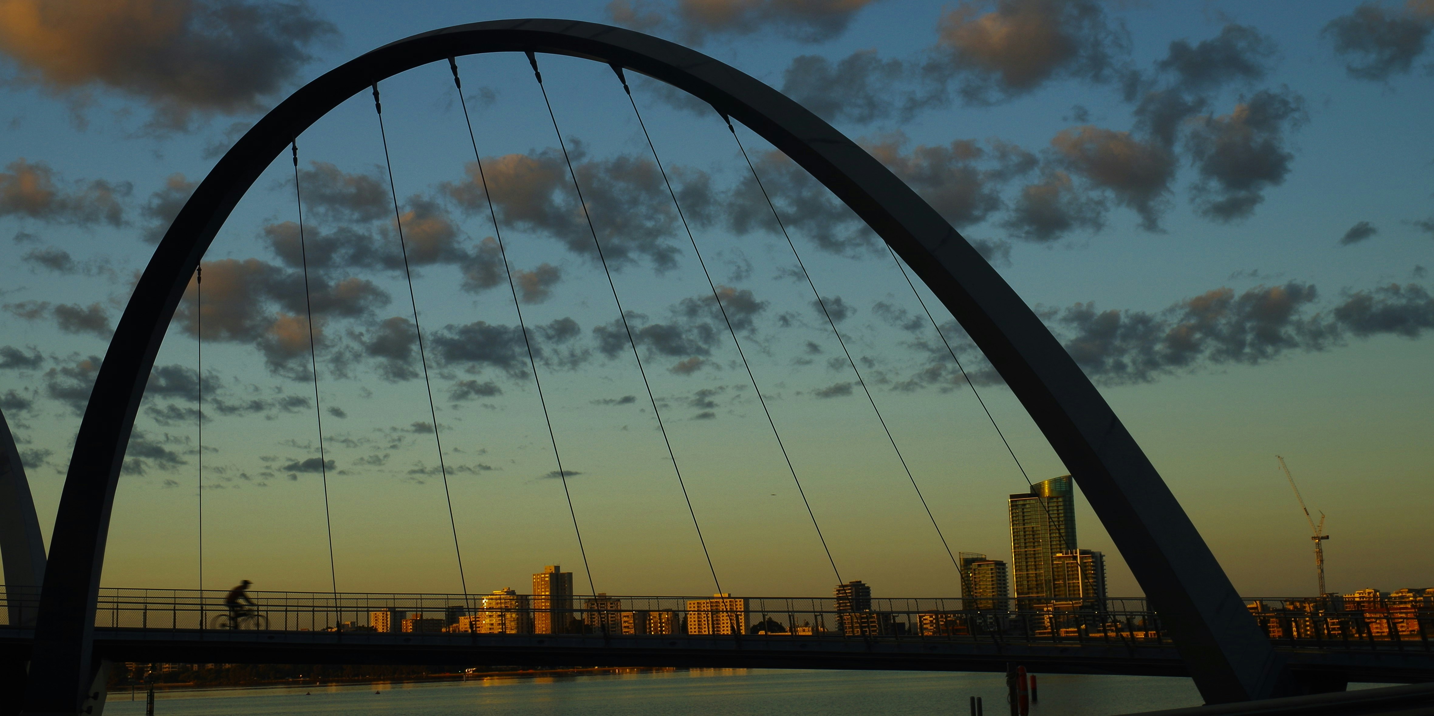 Urban Silhouettes: A Bicycle Journey Under the Arch