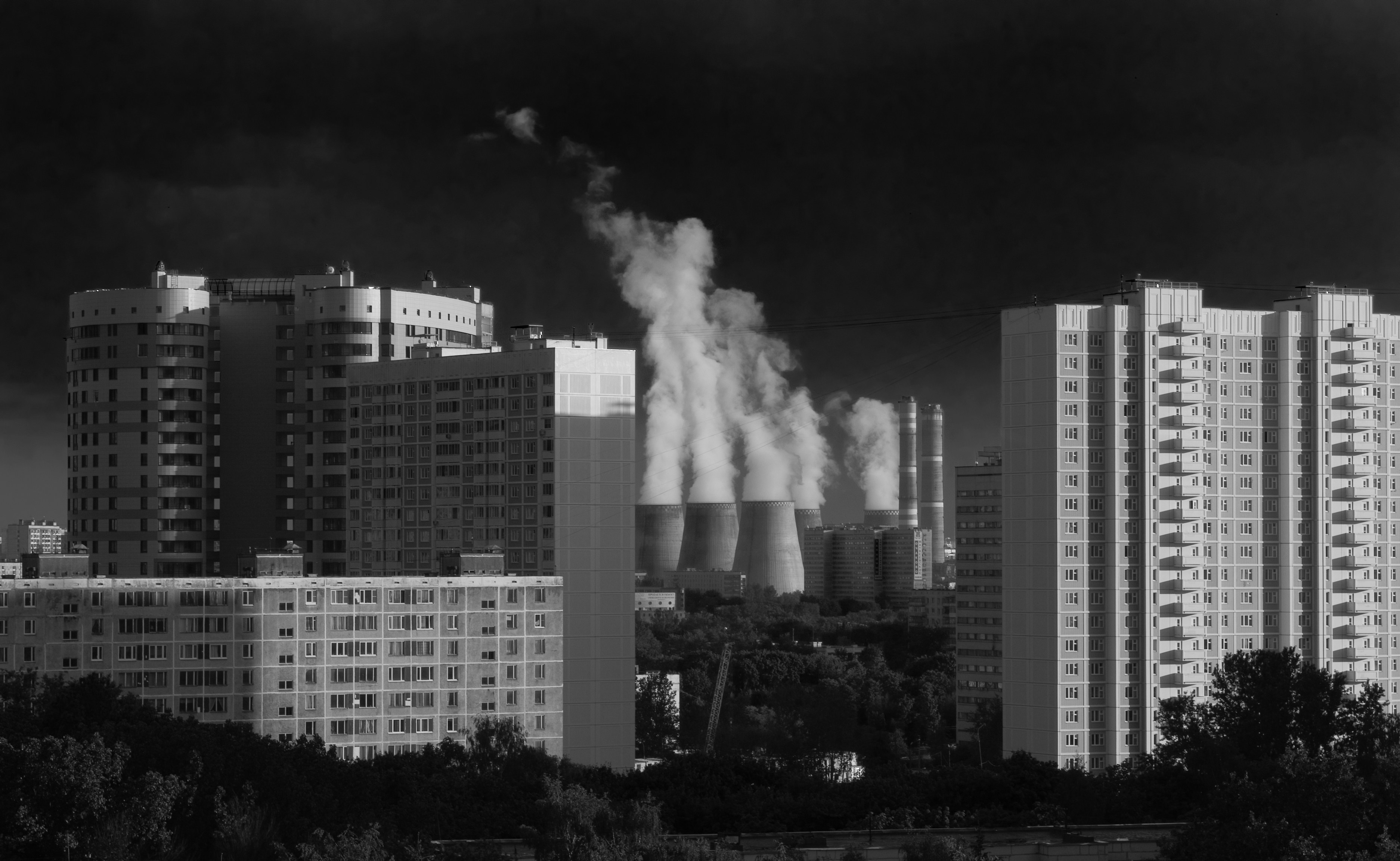Industrial chimneys emitting steam over apartment buildings