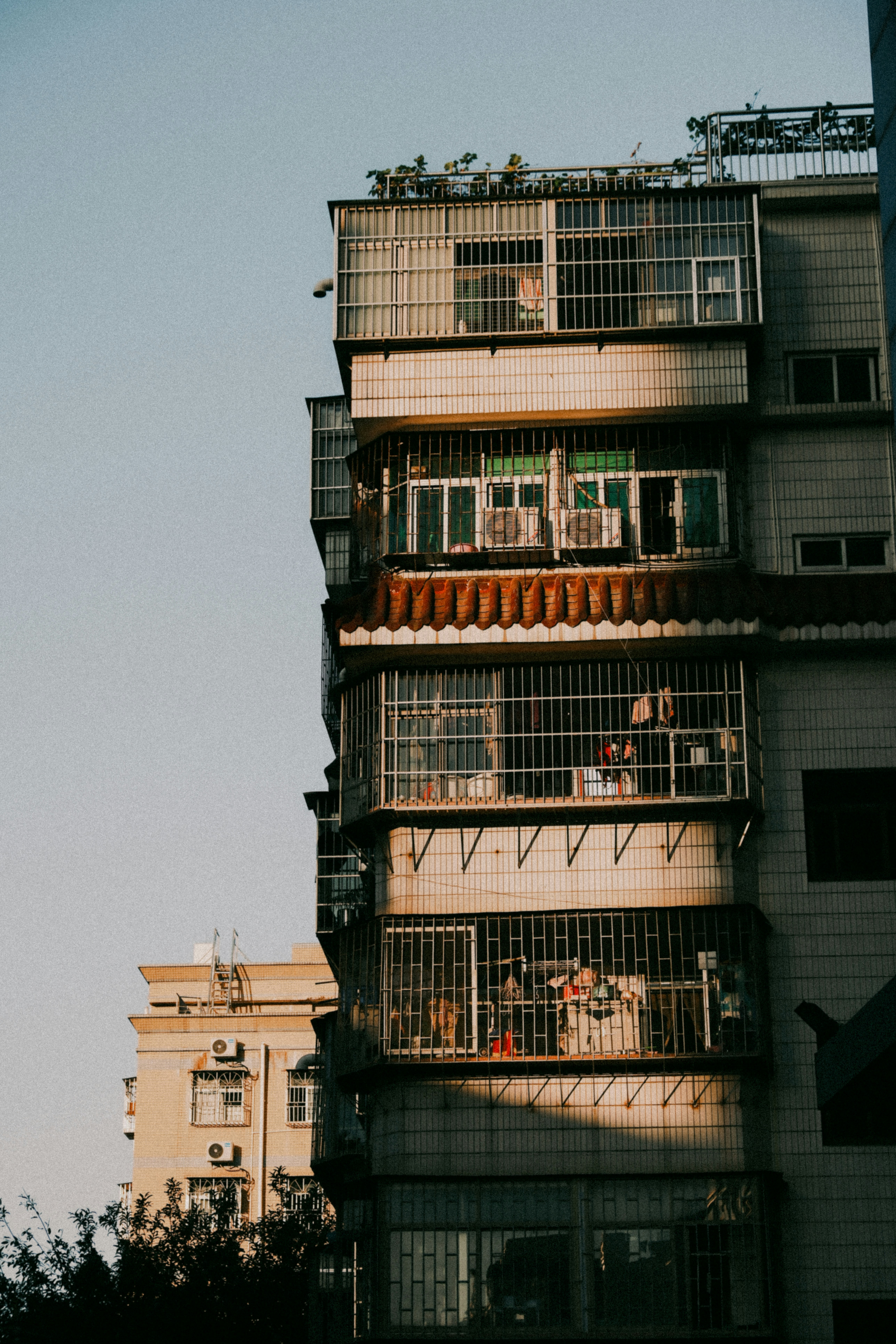 Tall apartment building with balconies against blue sky