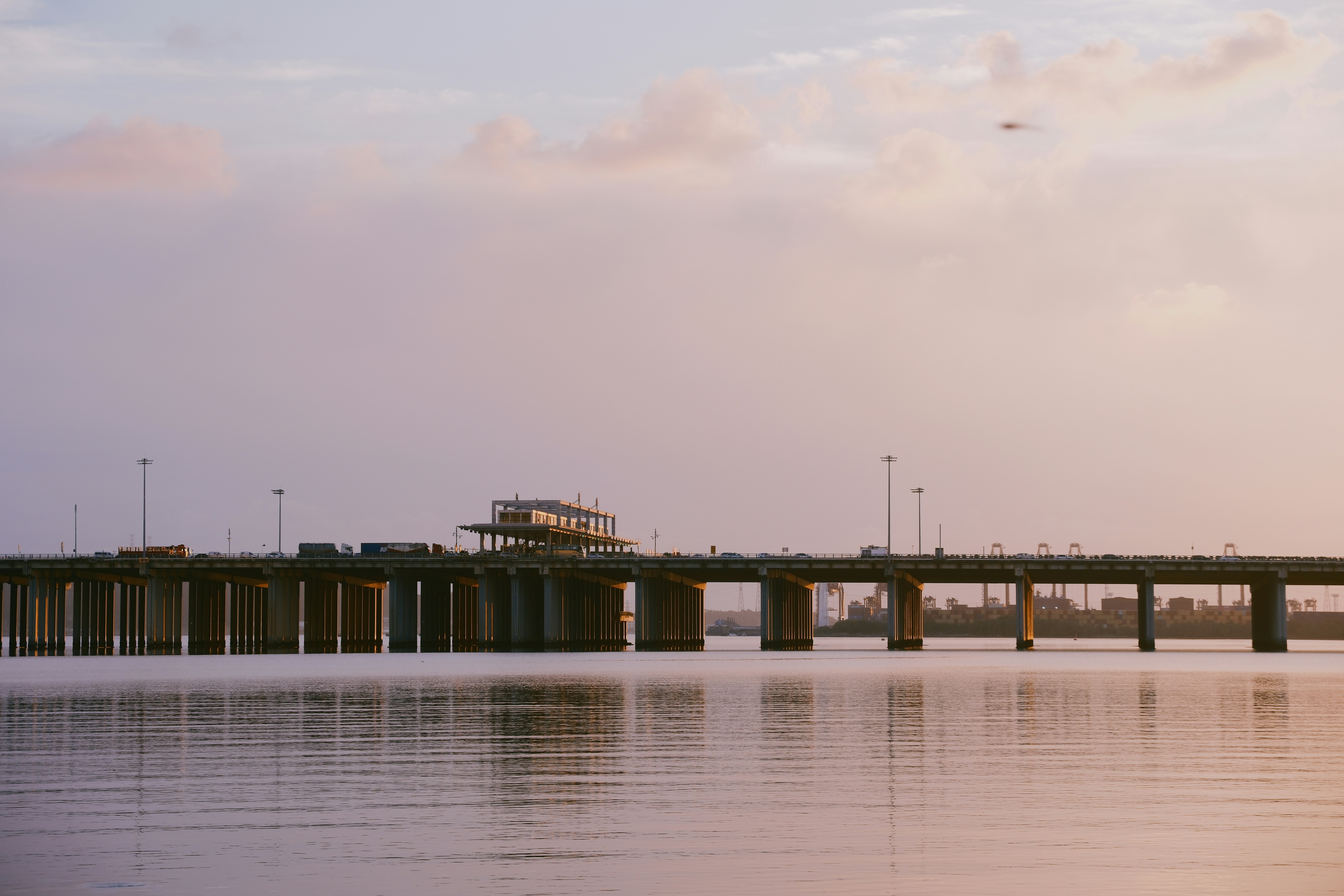 Long pier over calm water at sunset