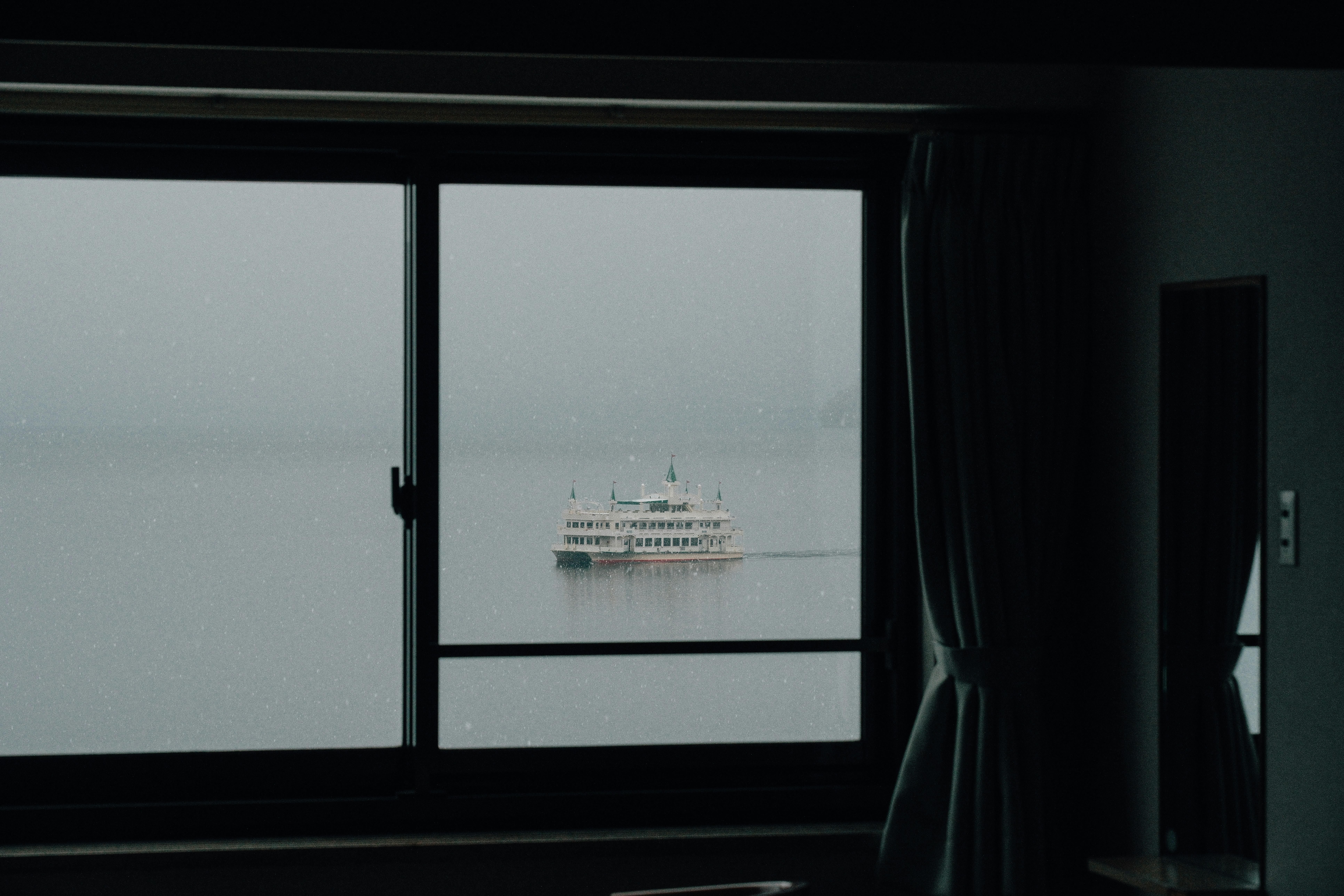 A boat sails on a misty lake seen through a window. photo – Free Lake ...