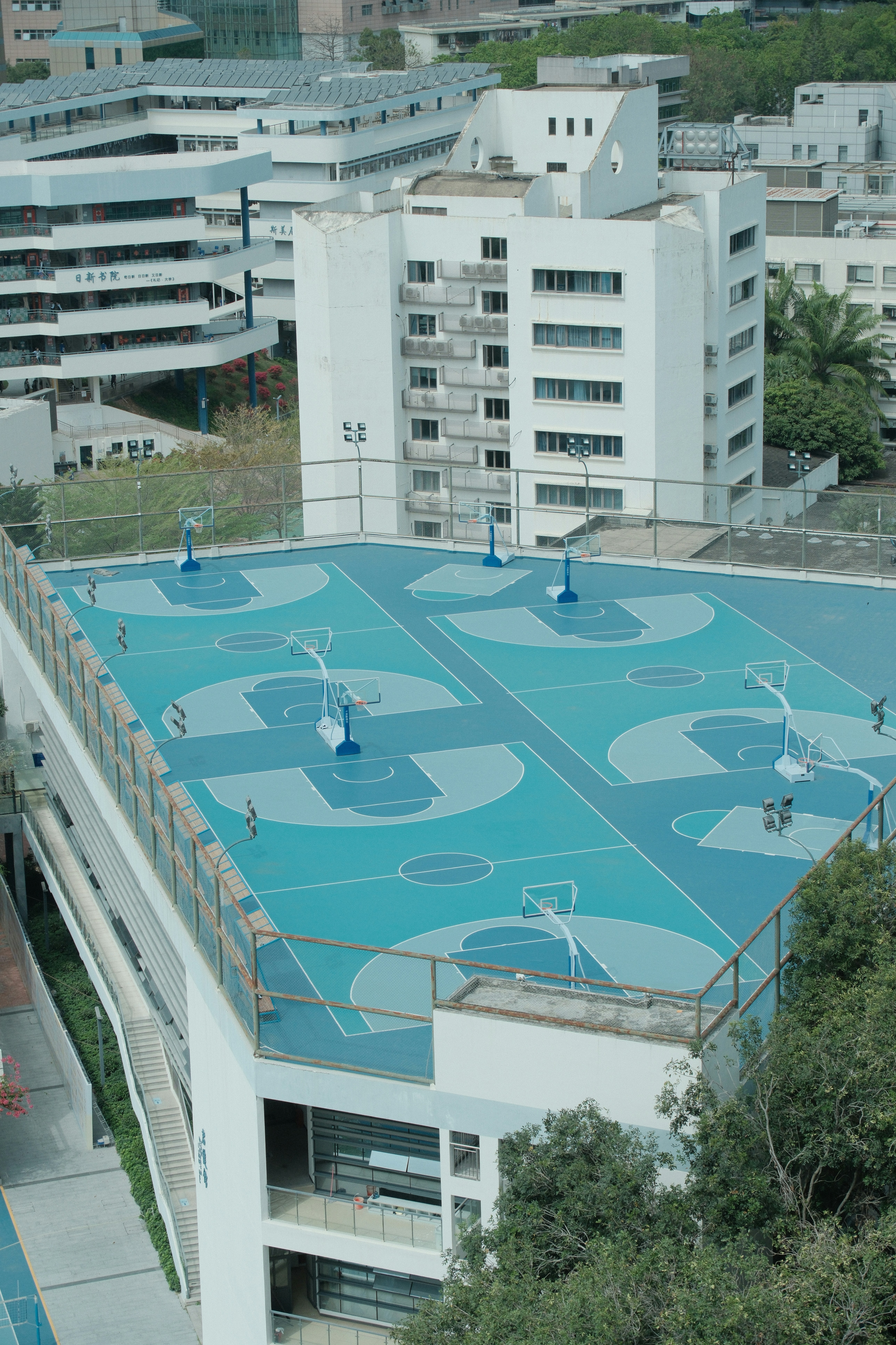 Rooftop basketball courts with blue markings and hoops.