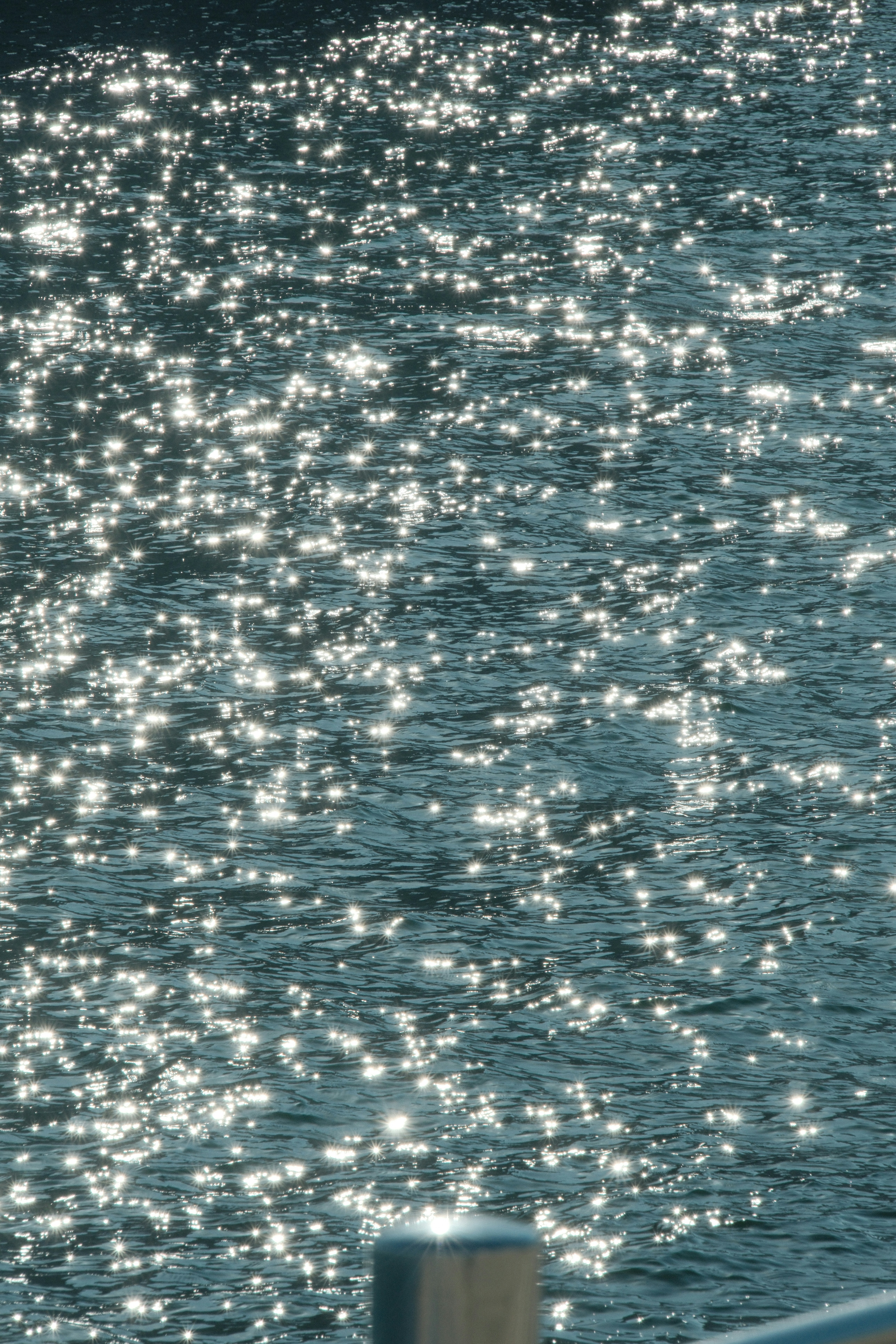 Sparkling sunlight reflects on dark rippling water