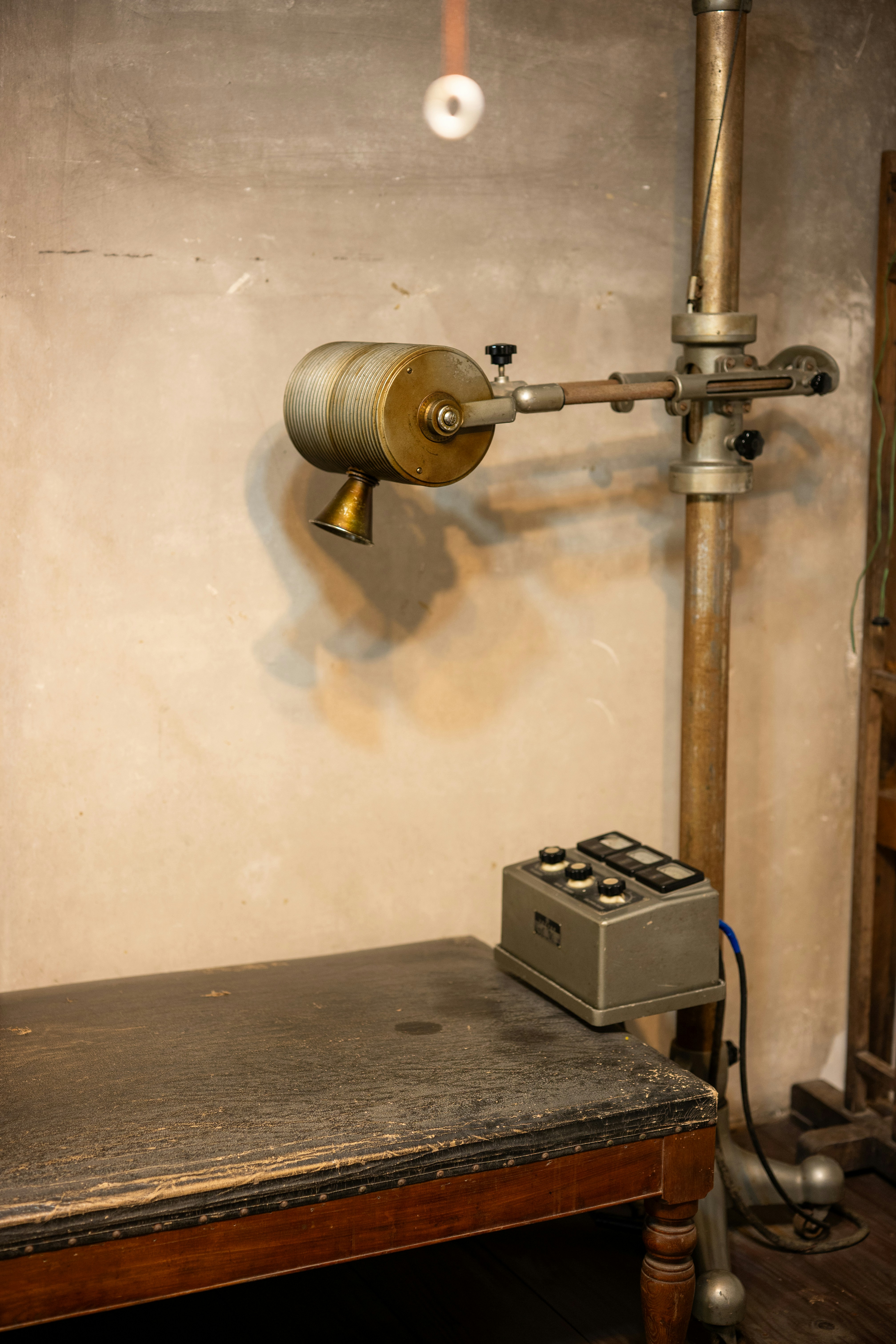 Vintage medical equipment with examination table and control box.