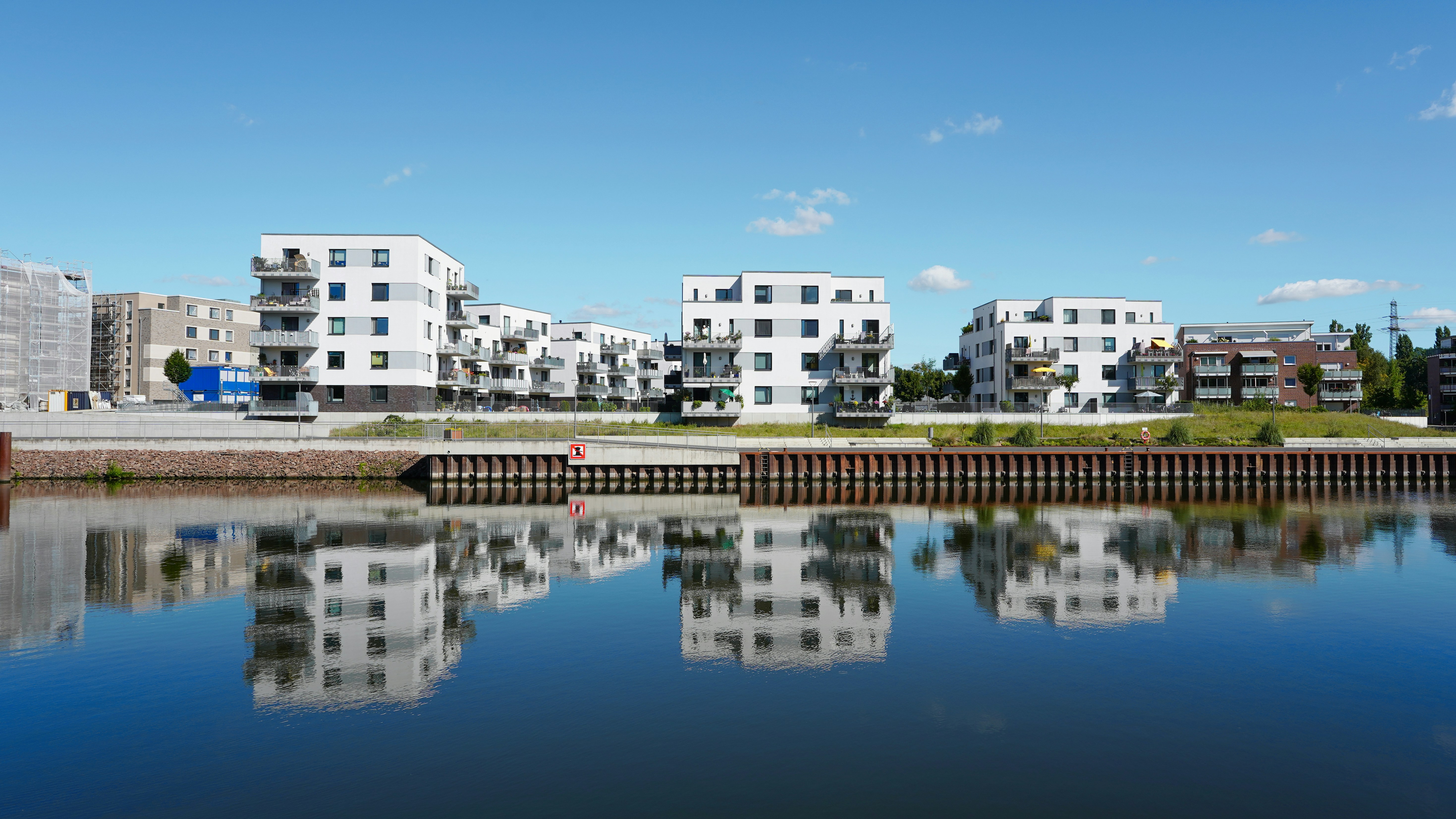 Modern white apartment buildings reflected in water