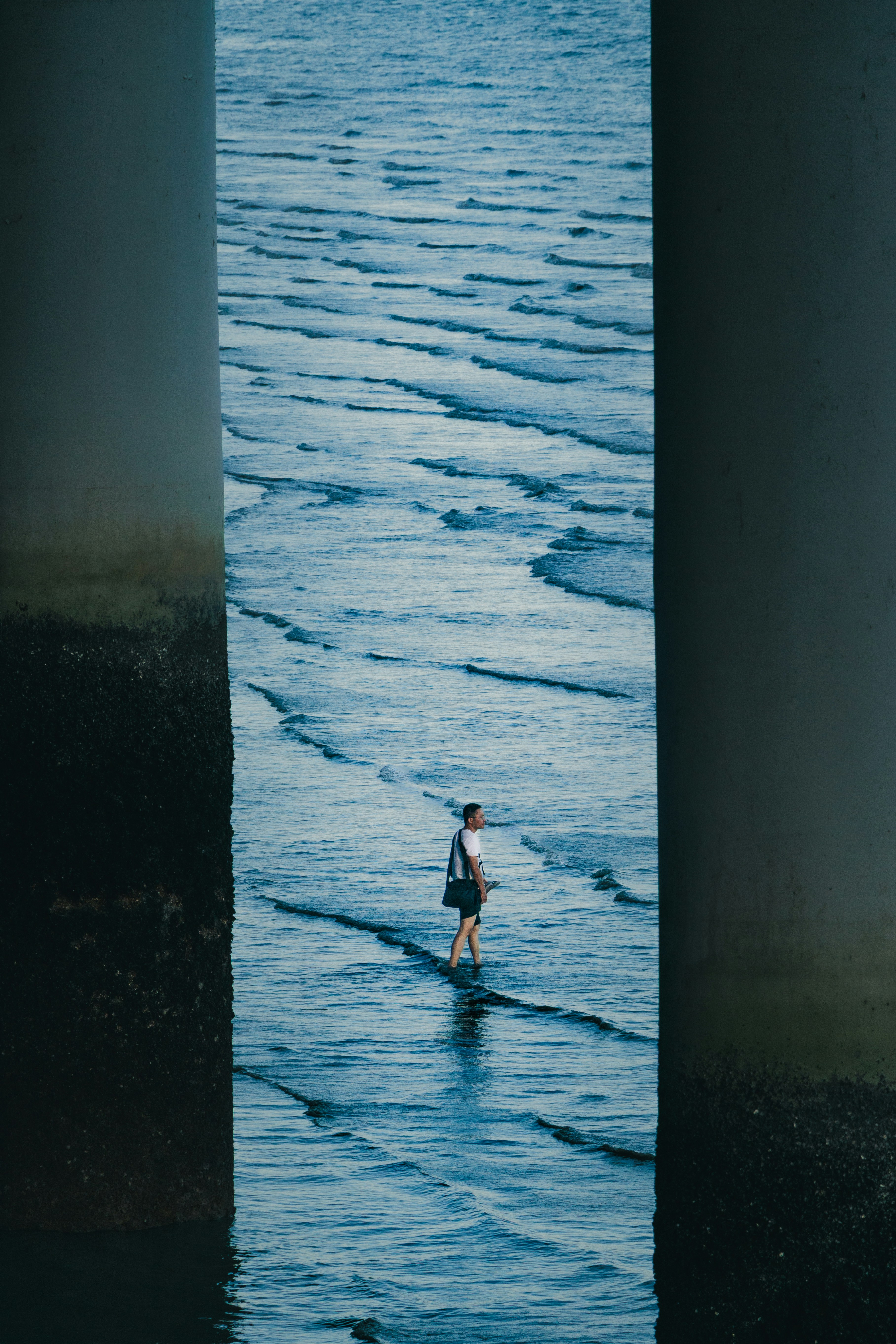 Man walks through shallow ocean waves