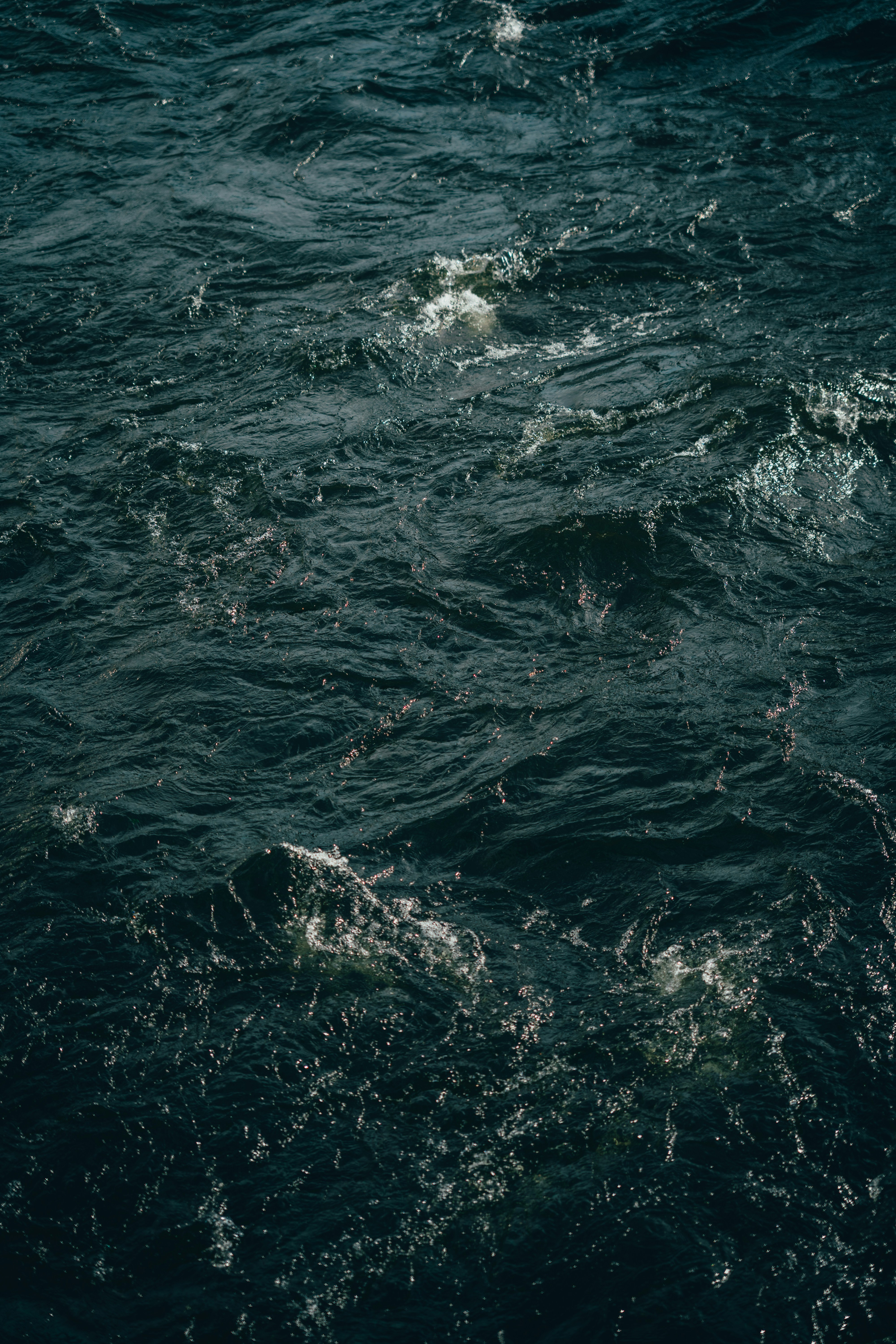 Dark, choppy water with white foam and splashes