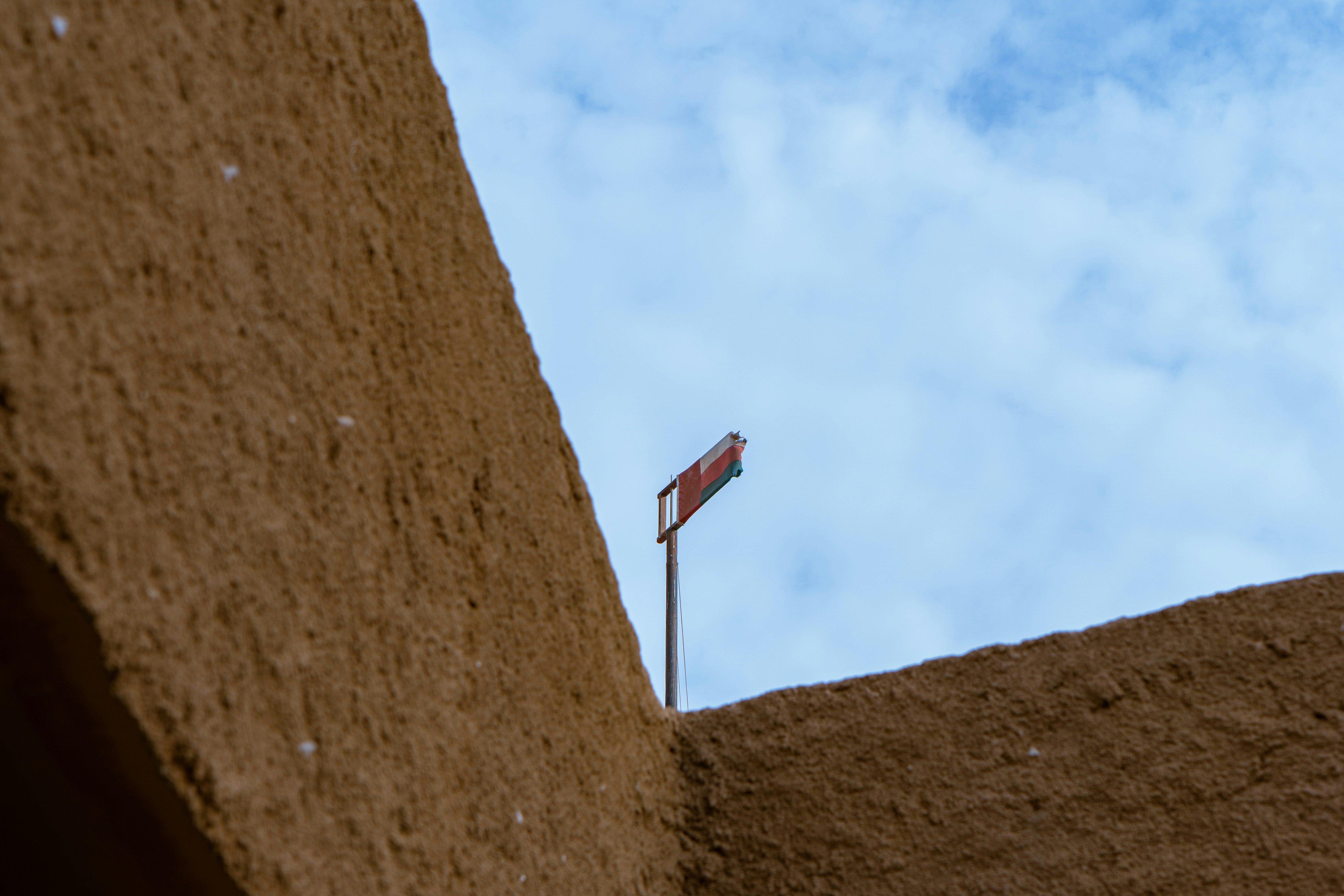 Brown textured wall against a blue sky.