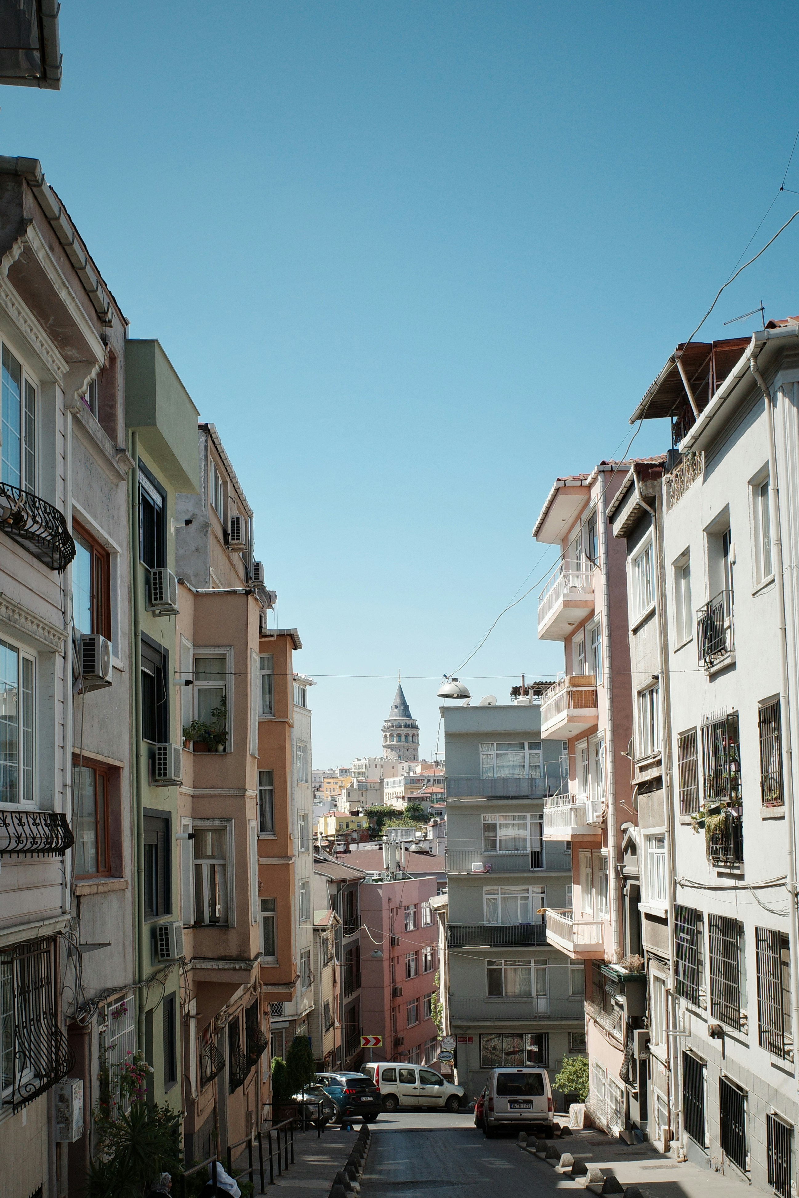 Narrow street with colorful buildings and distant tower.