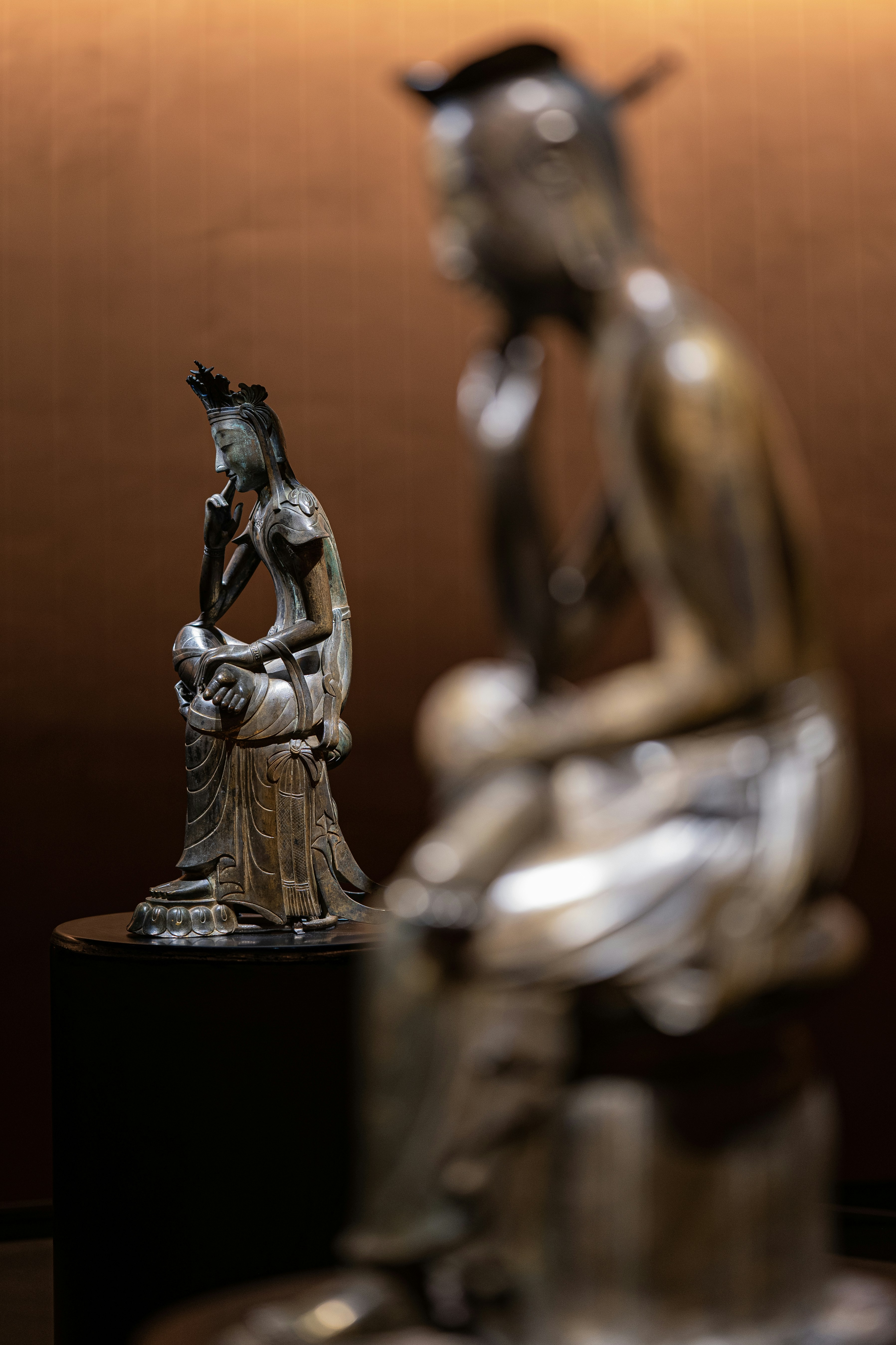 Two ancient bronze statues of seated figures in contemplation. photo ...