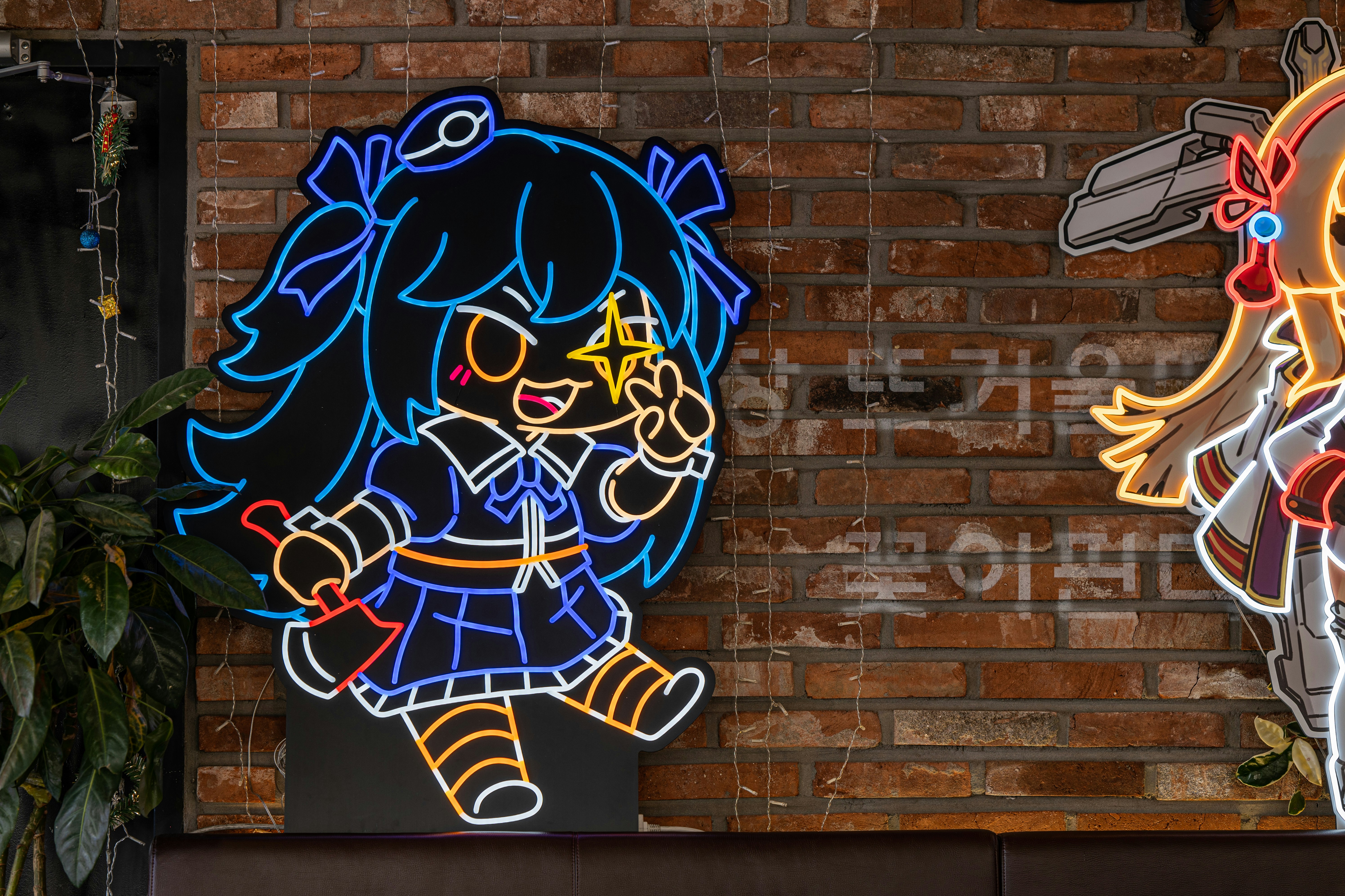 A colorful neon illustration of a cheerful character with blue hair and a playful pose, set against a textured brick wall. The scene is enhanced by decorative lighting and greenery.