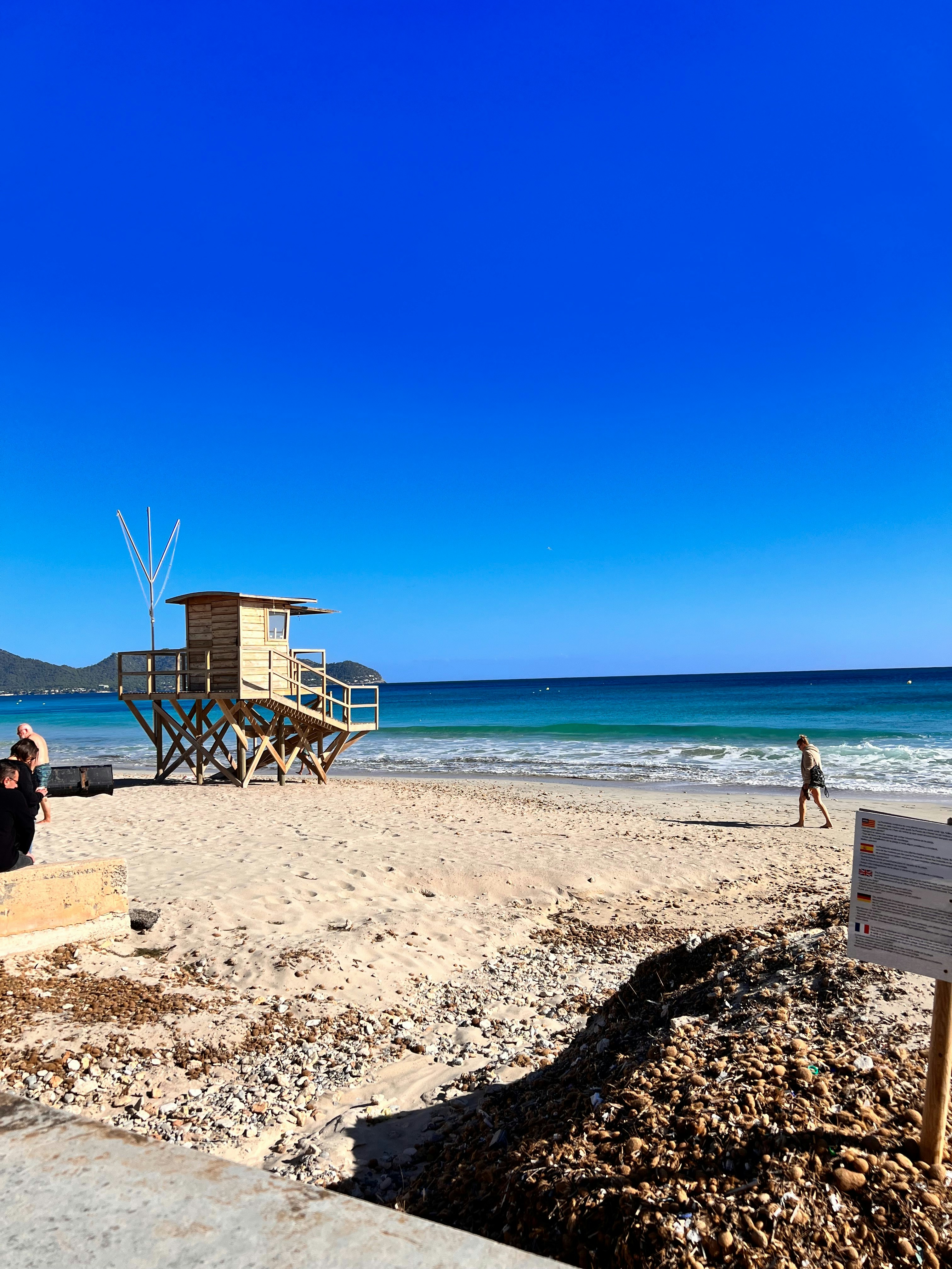 Lifeguard tower on a sandy beach with blue ocean.