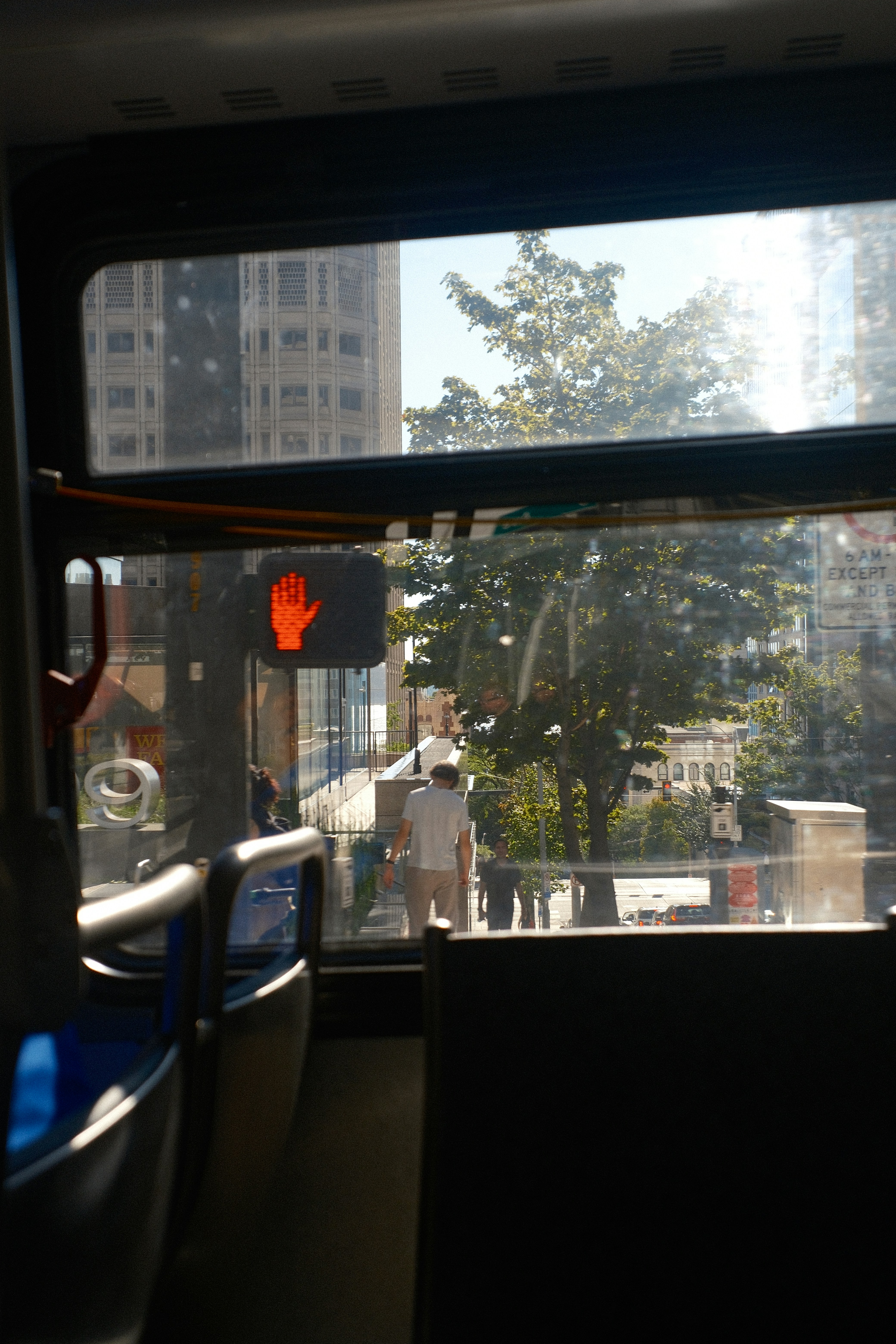 View from bus window of city street with pedestrian crossing signal ...