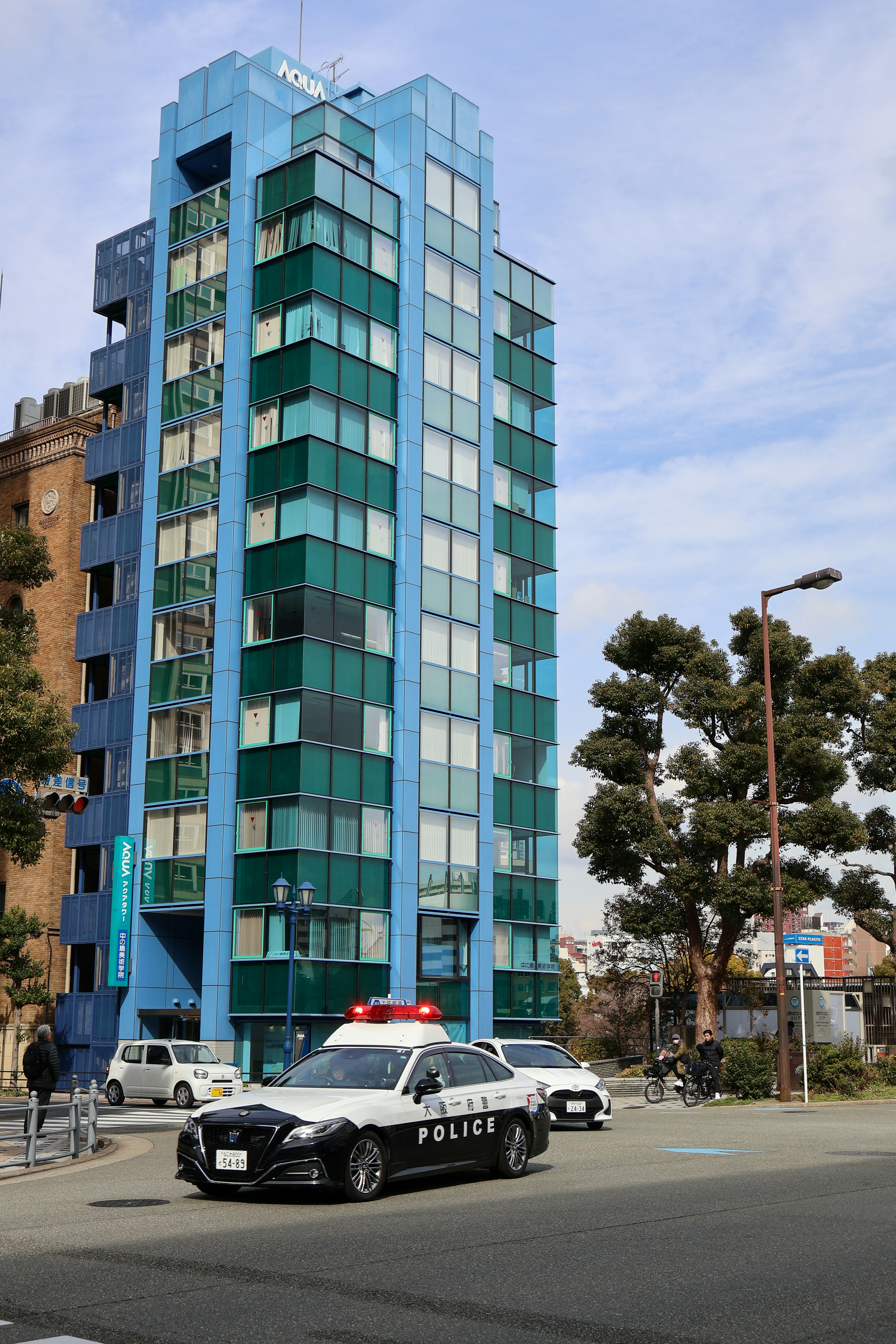 Police car in front of a blue modern building.