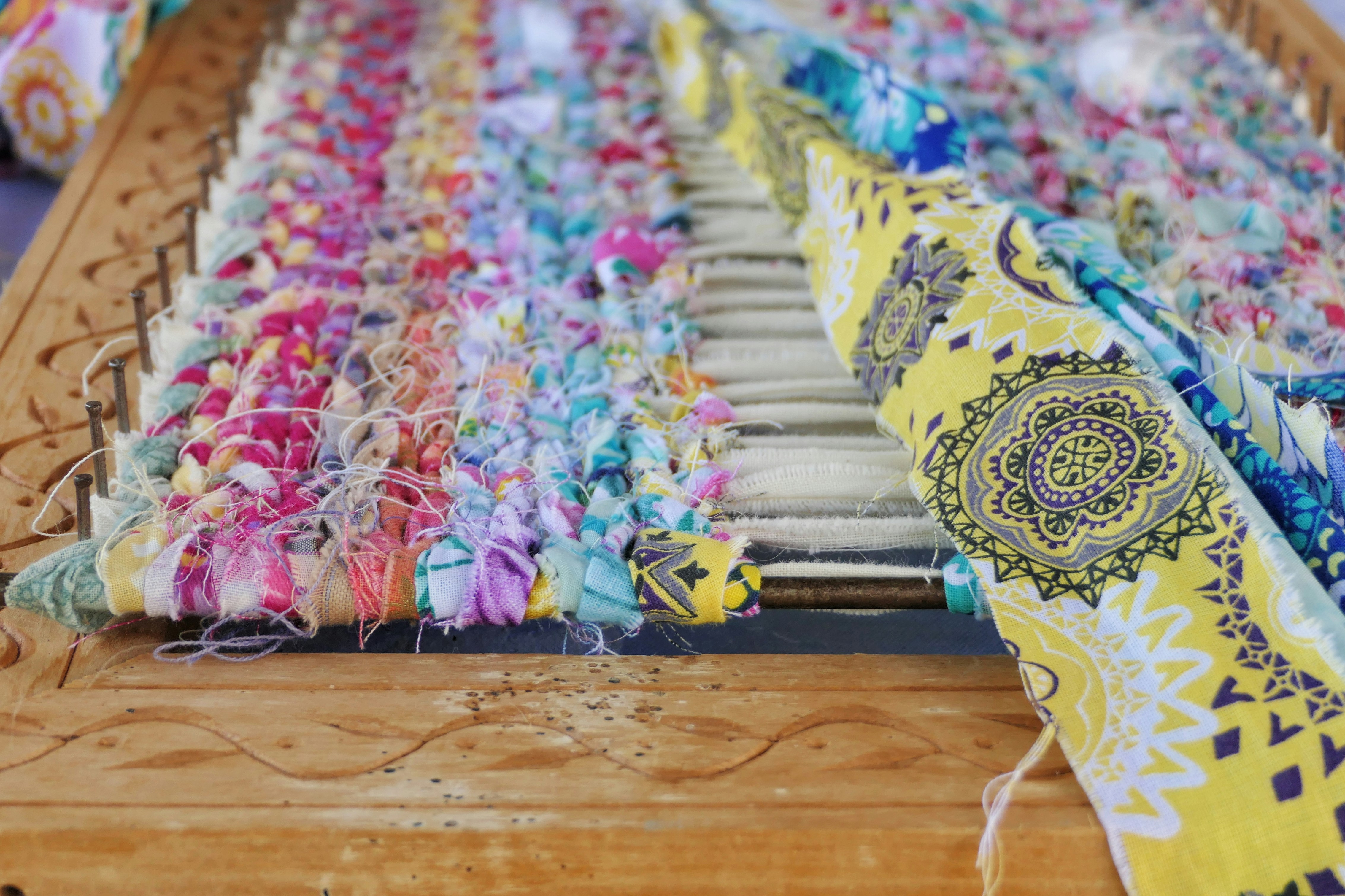 old form of weaving known as twining | Colorful rag rug being woven on a wooden loom.