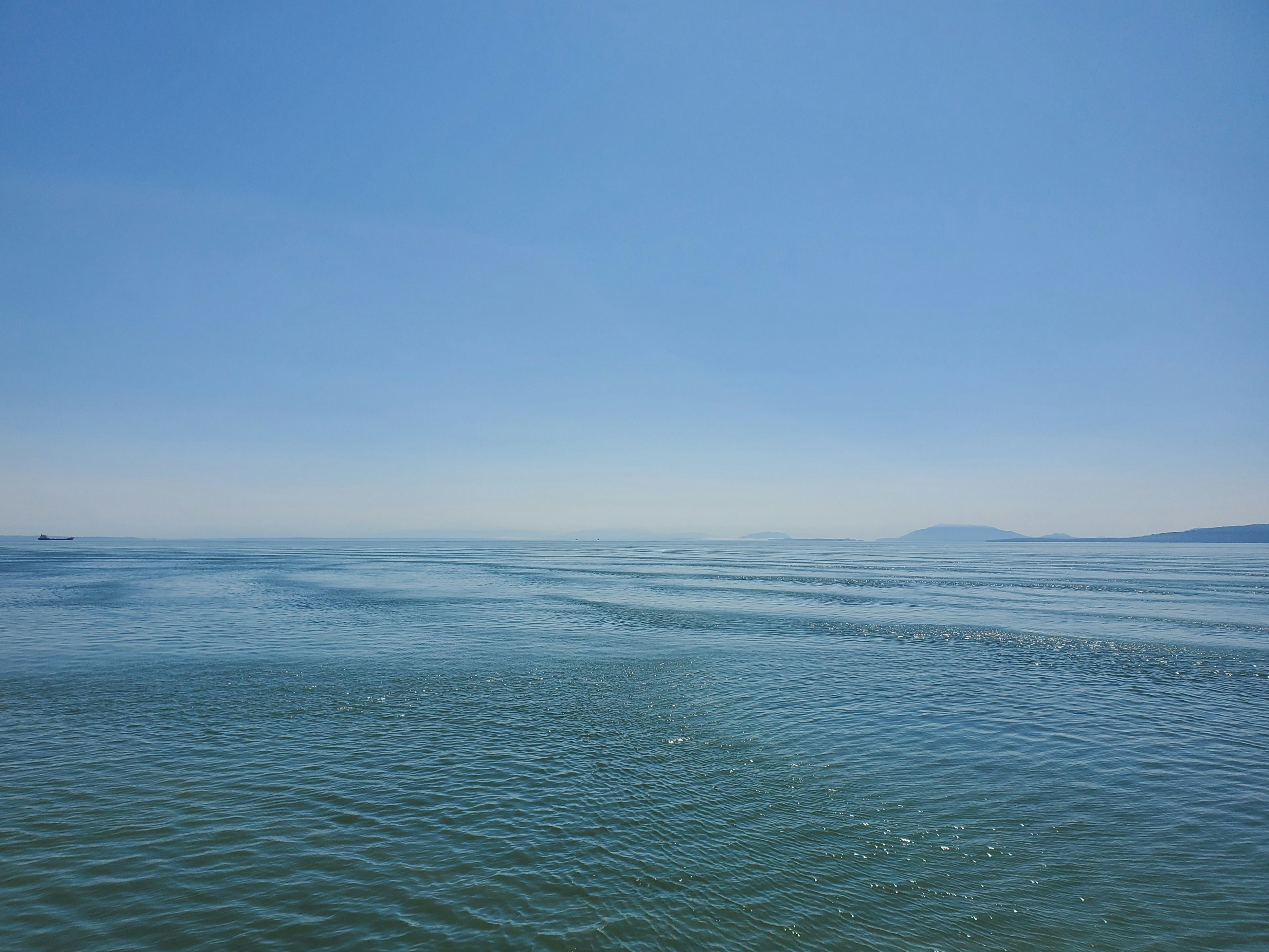 Clear blue sky over calm ocean water